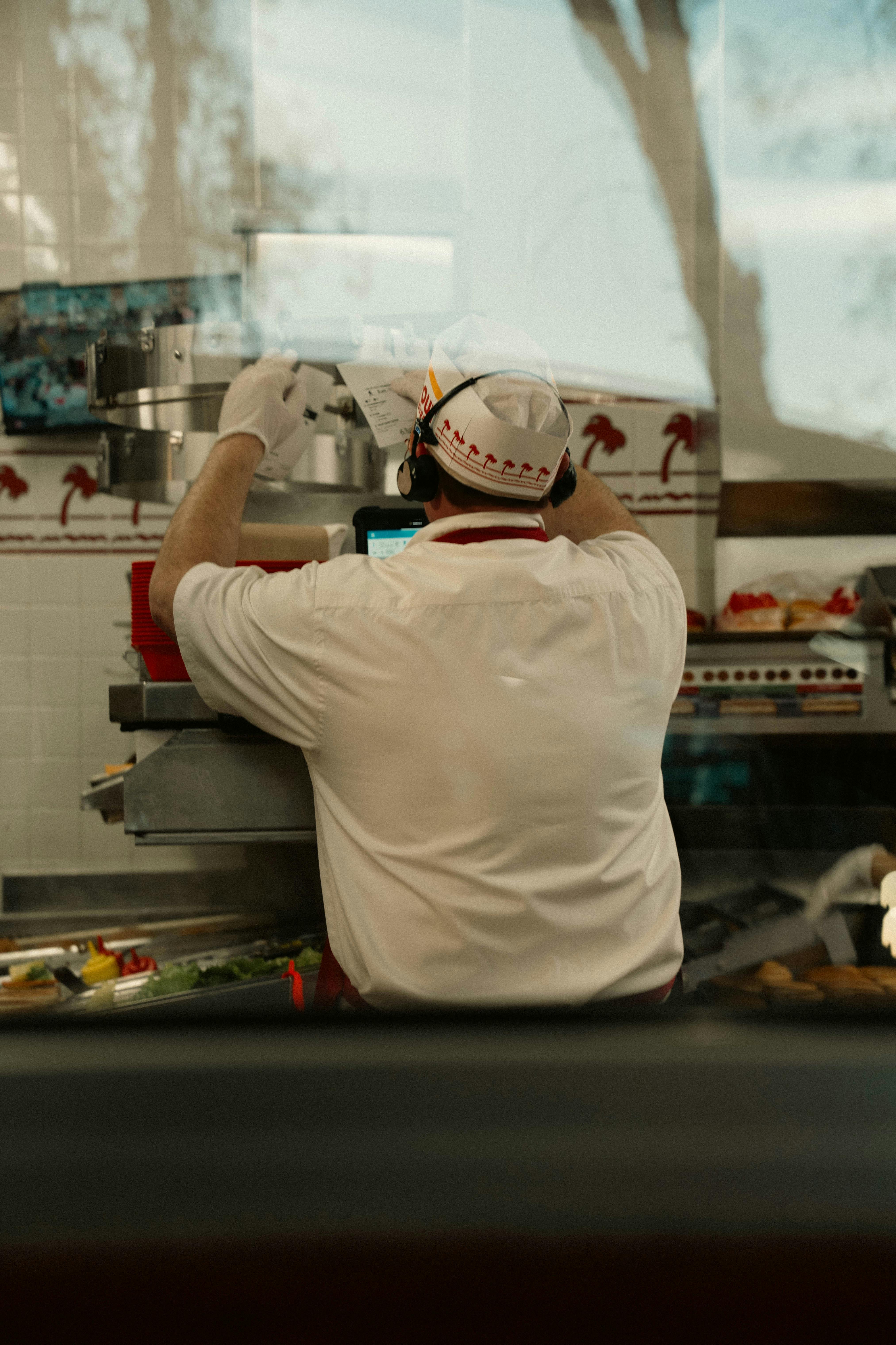 Fast food restaurant worker at the grill station · Free Stock Photo