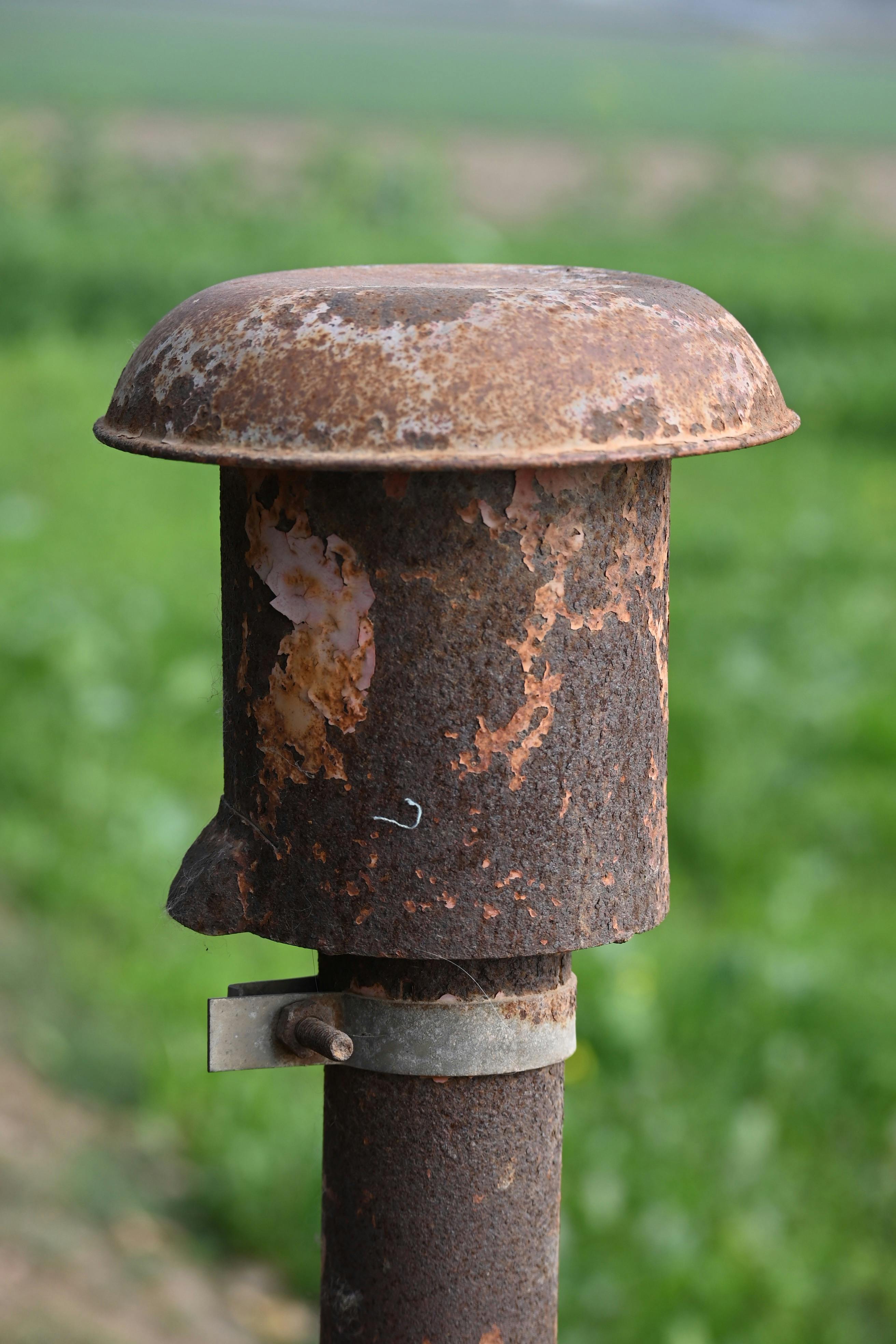Rusty Vent Pipe in a Green Field Setting · Free Stock Photo