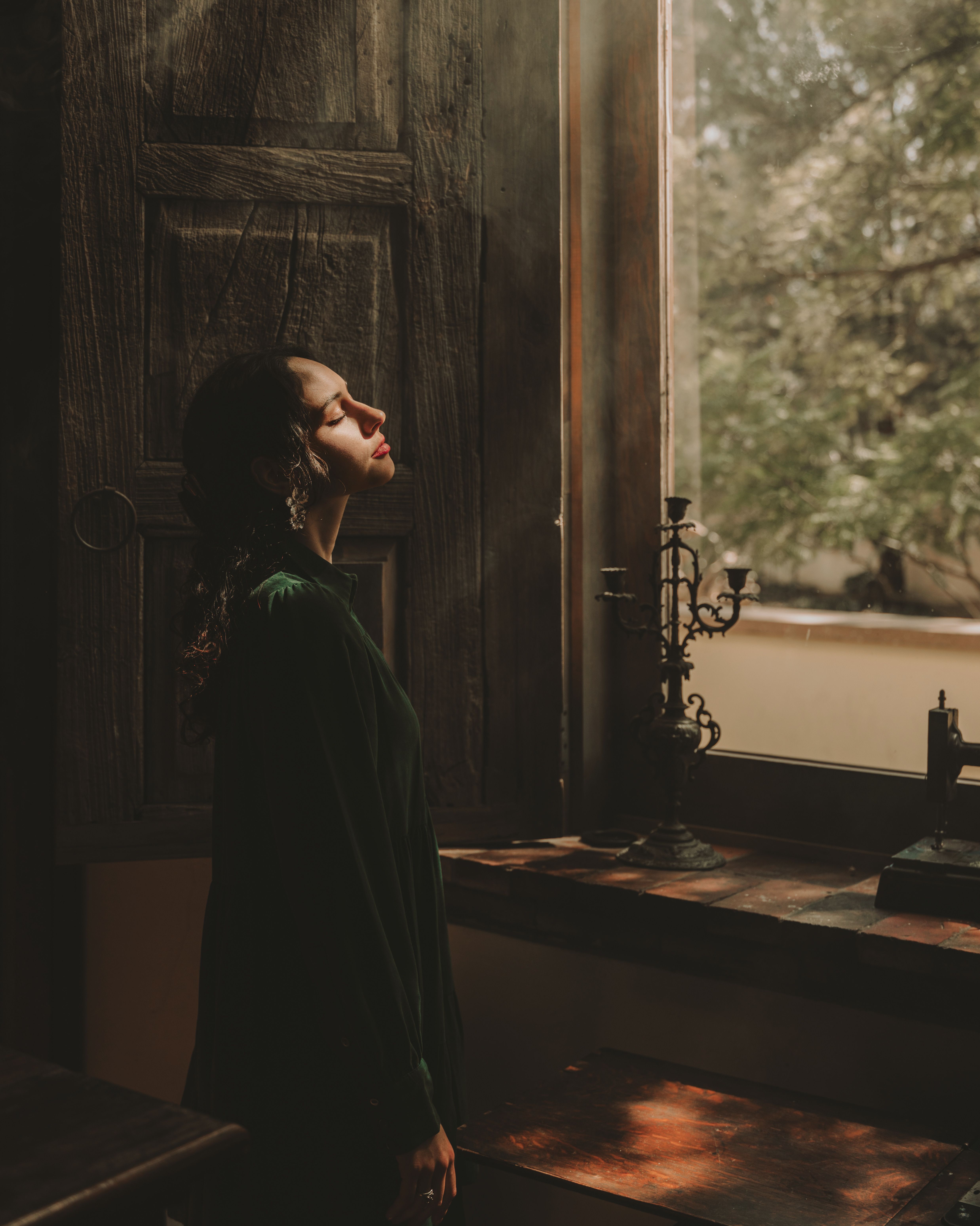 Woman in Dark Room Dreamily Staring Out Window · Free Stock Photo