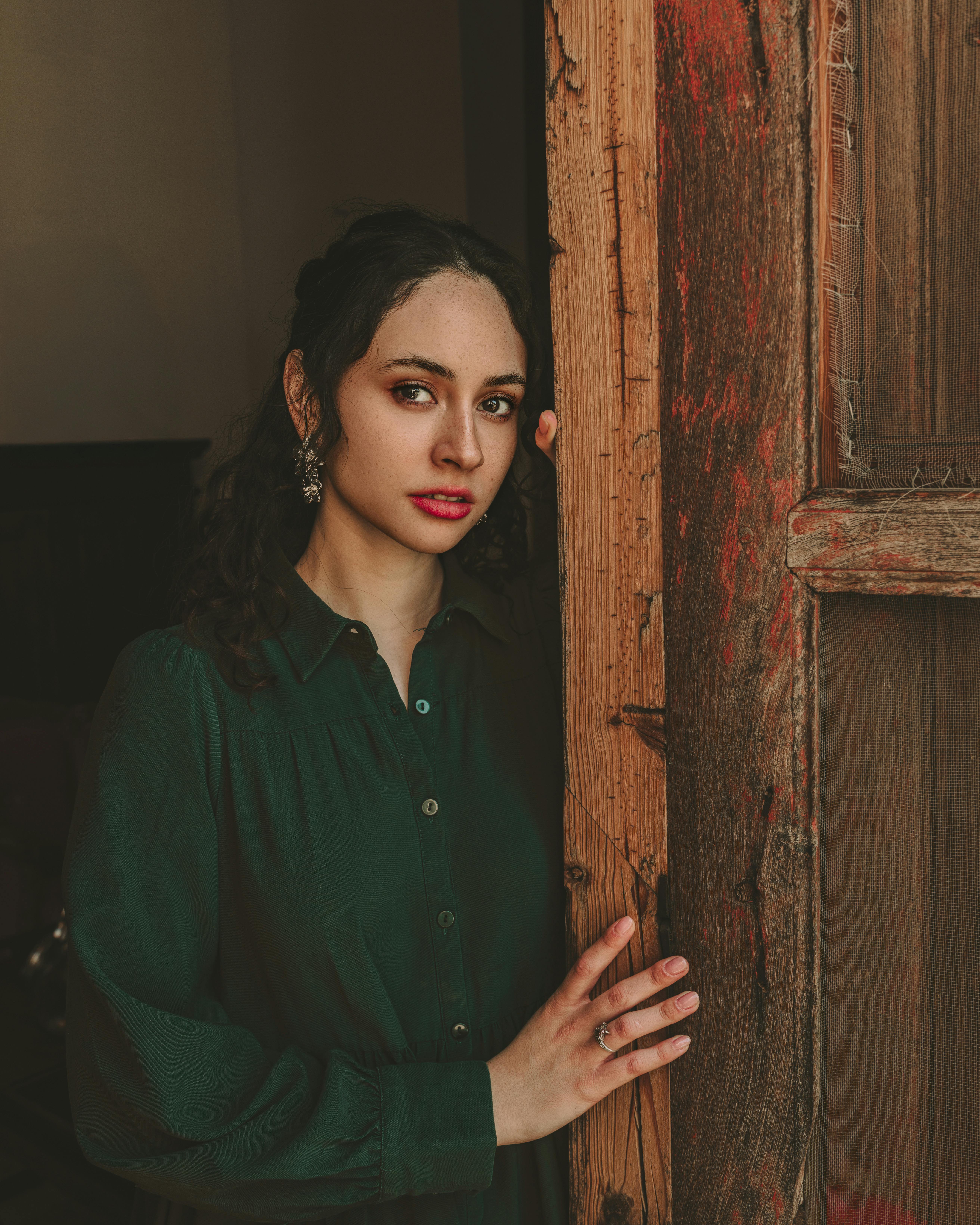 Elegant Woman in Rustic Wooden Doorway Setting · Free Stock Photo