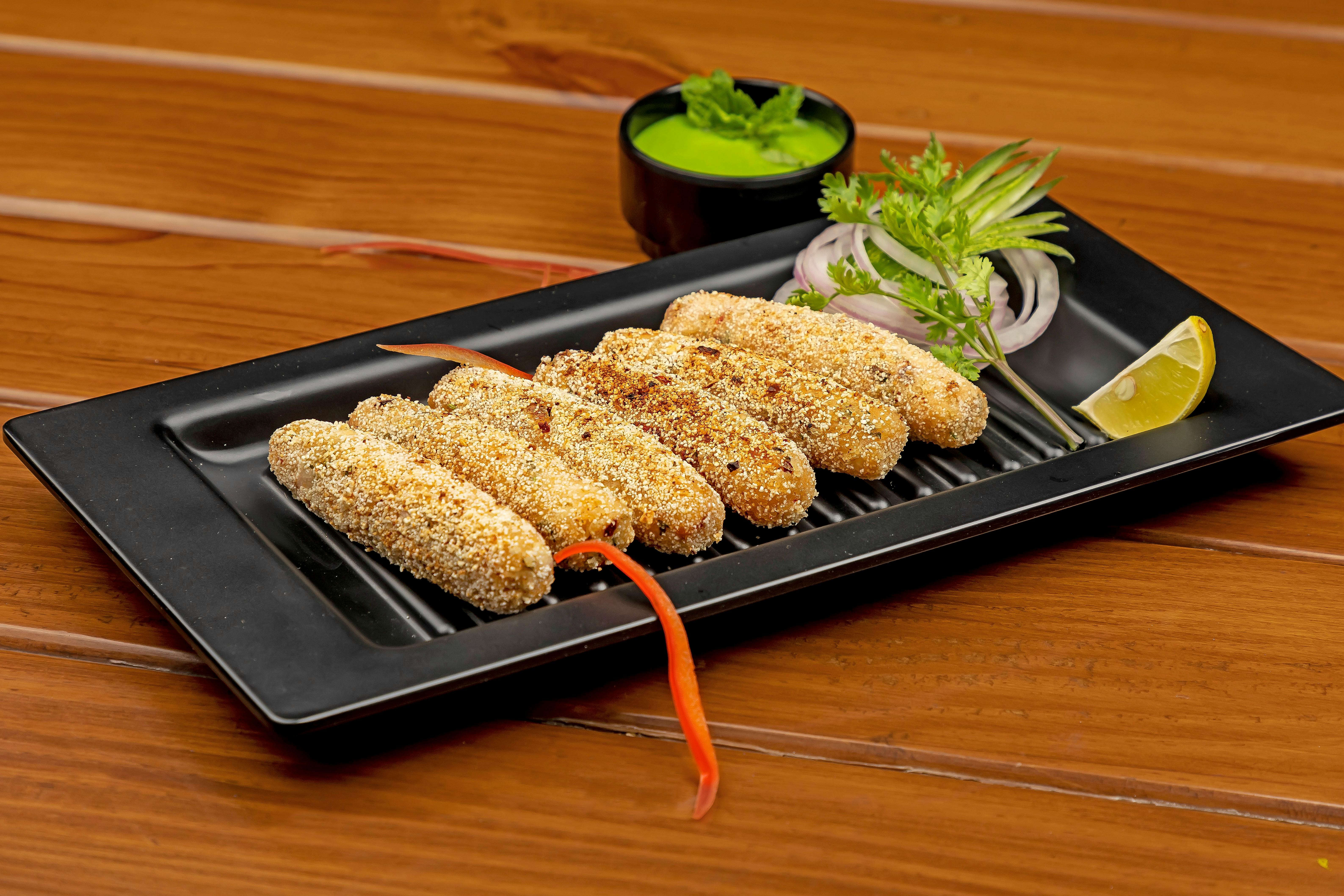 Crispy Finger Snacks with Green Sauce and Garnish · Free Stock Photo