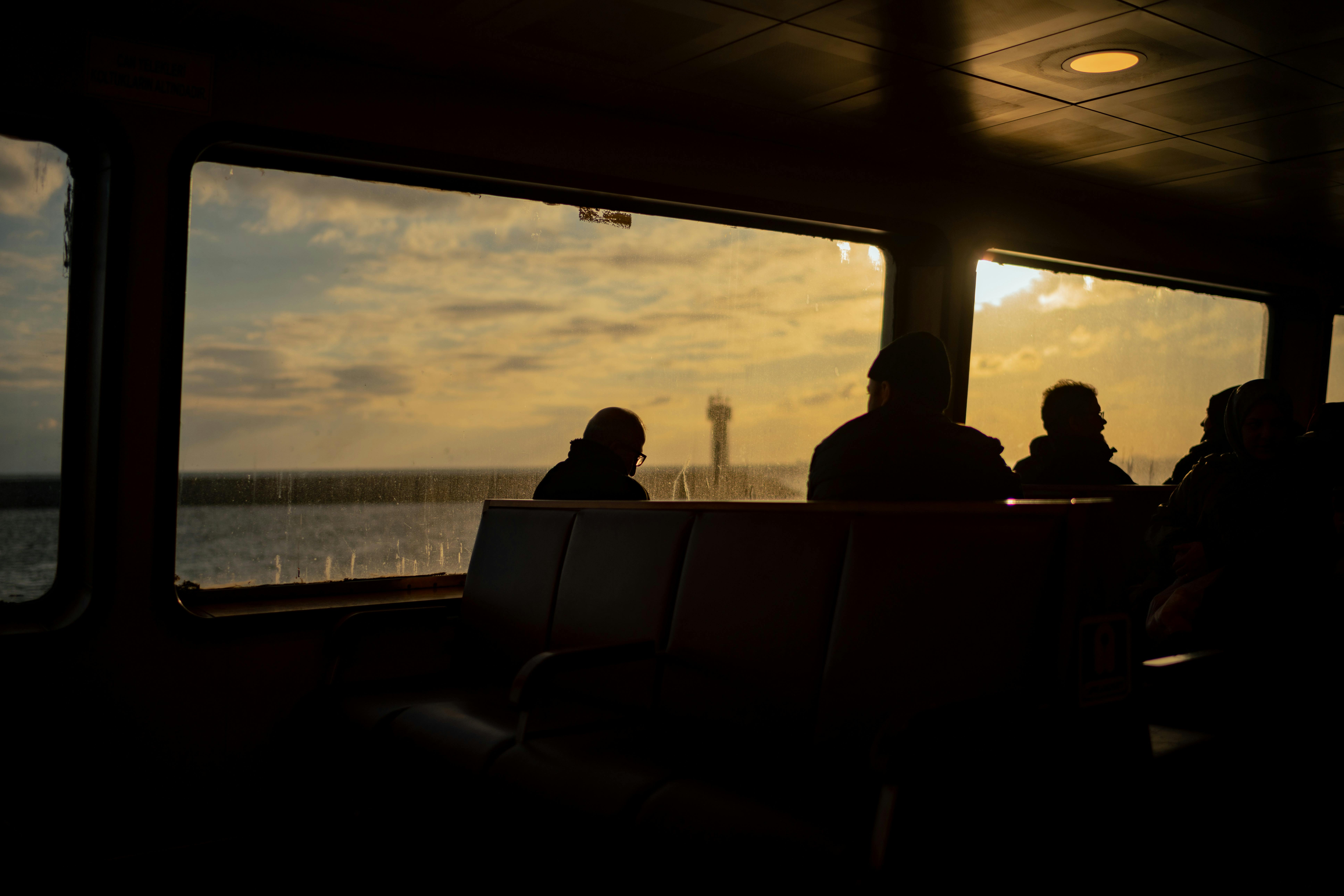 Sunset silhouettes inside a ferry cabin · Free Stock Photo