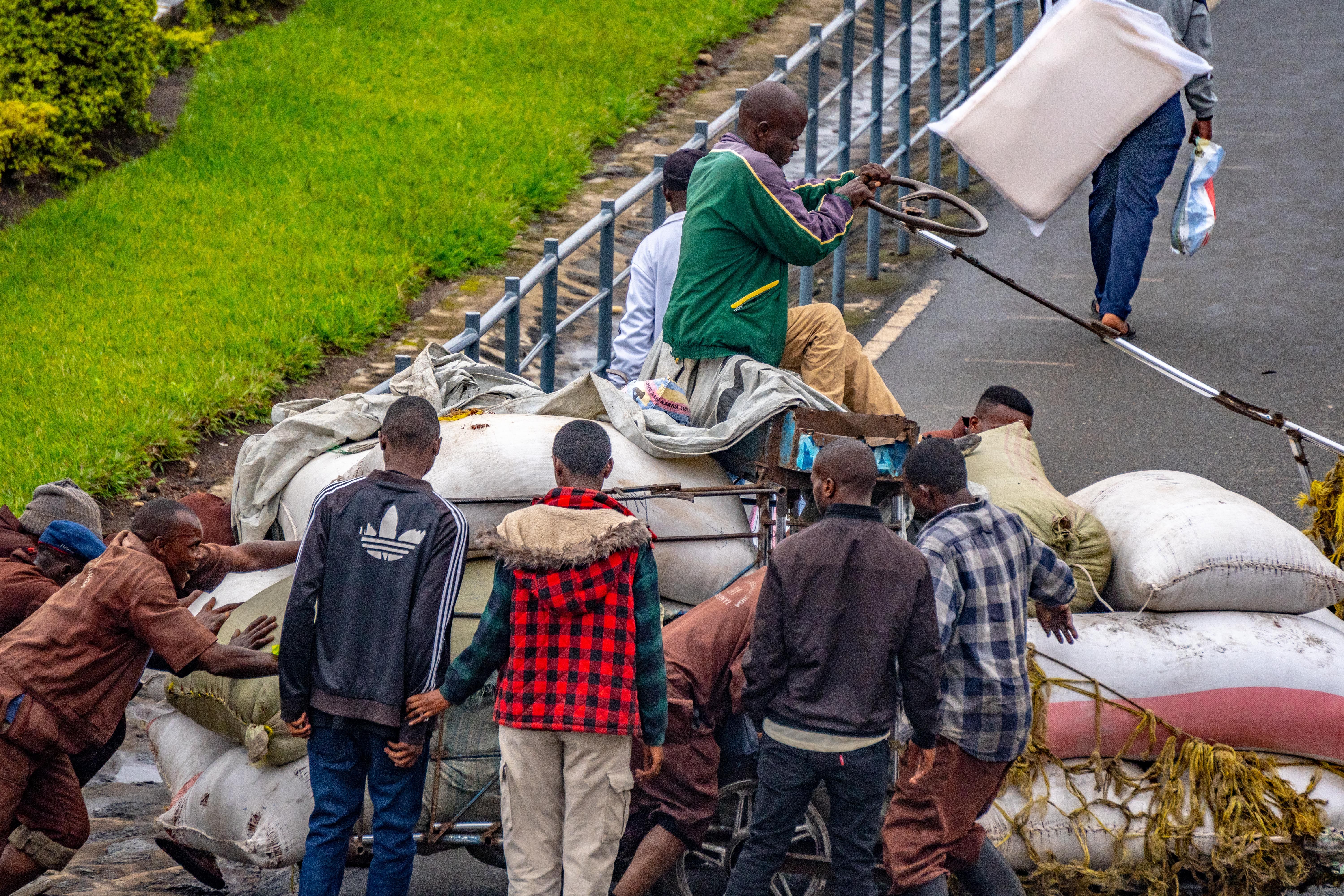 Group of Men Pushing a Large Cart on Street · Free Stock Photo