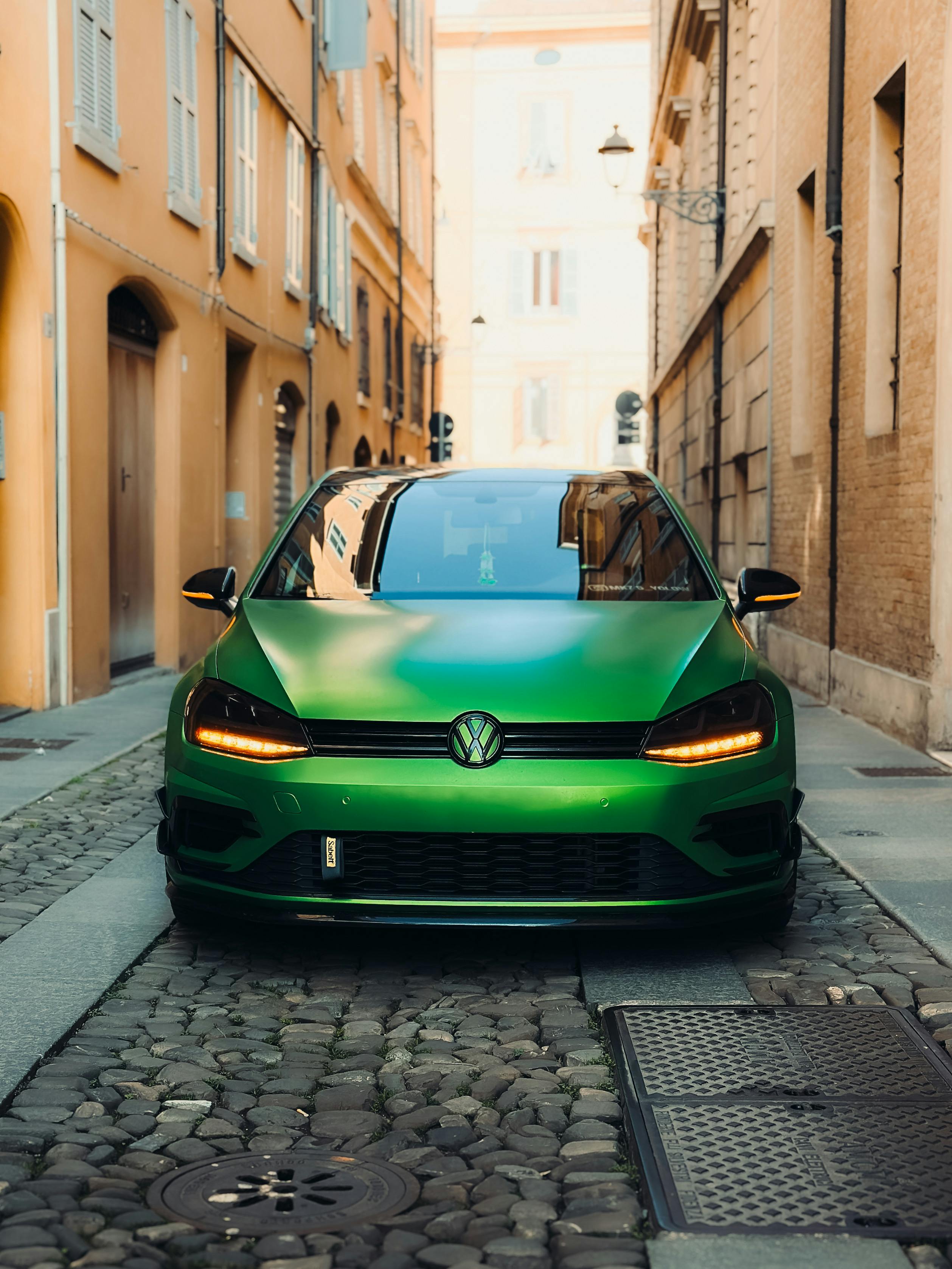 Urban Alley with Green Car on Cobblestone Street · Free Stock Photo