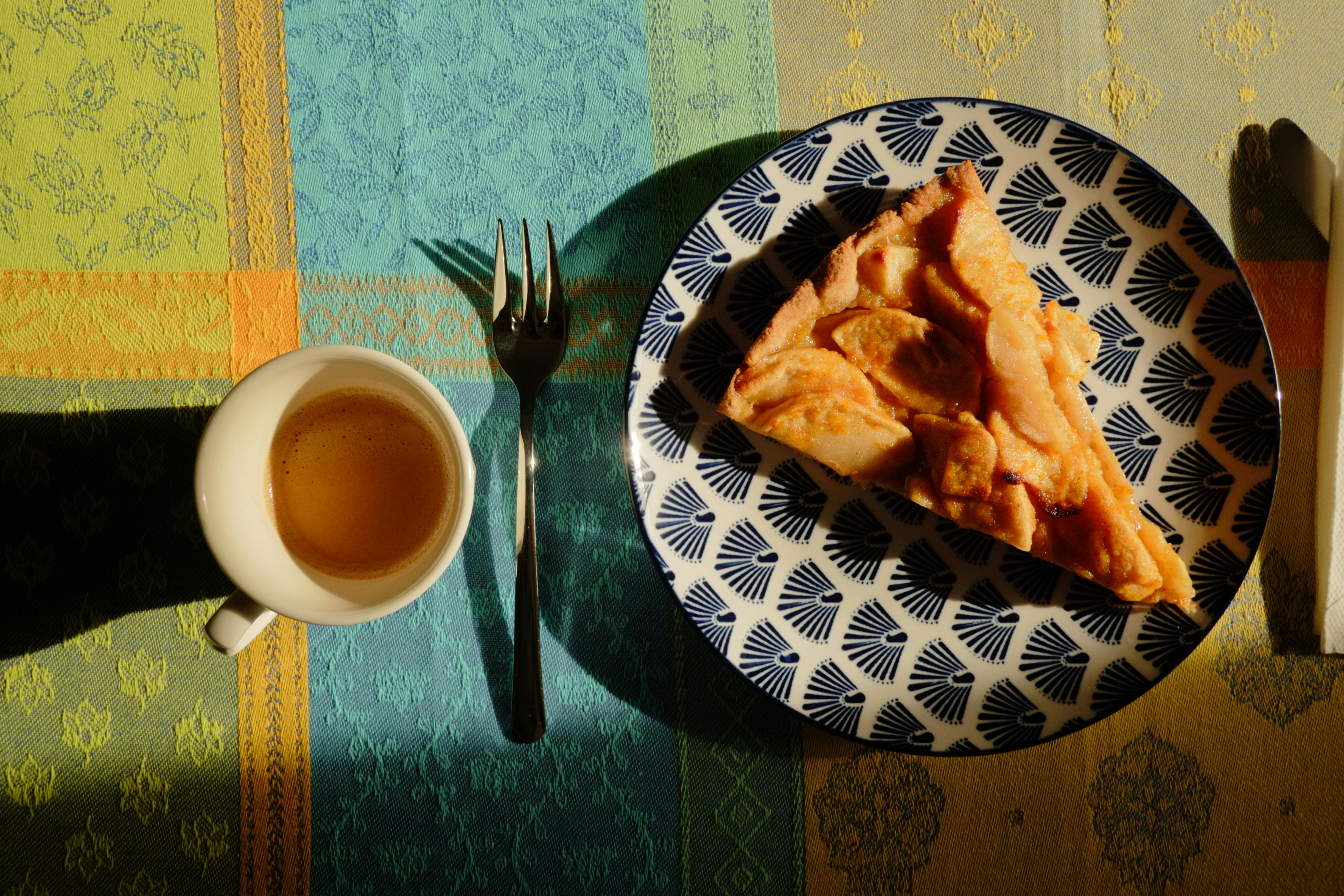 Apple Pie Slice and Espresso on Patterned Tablecloth · Free Stock Photo