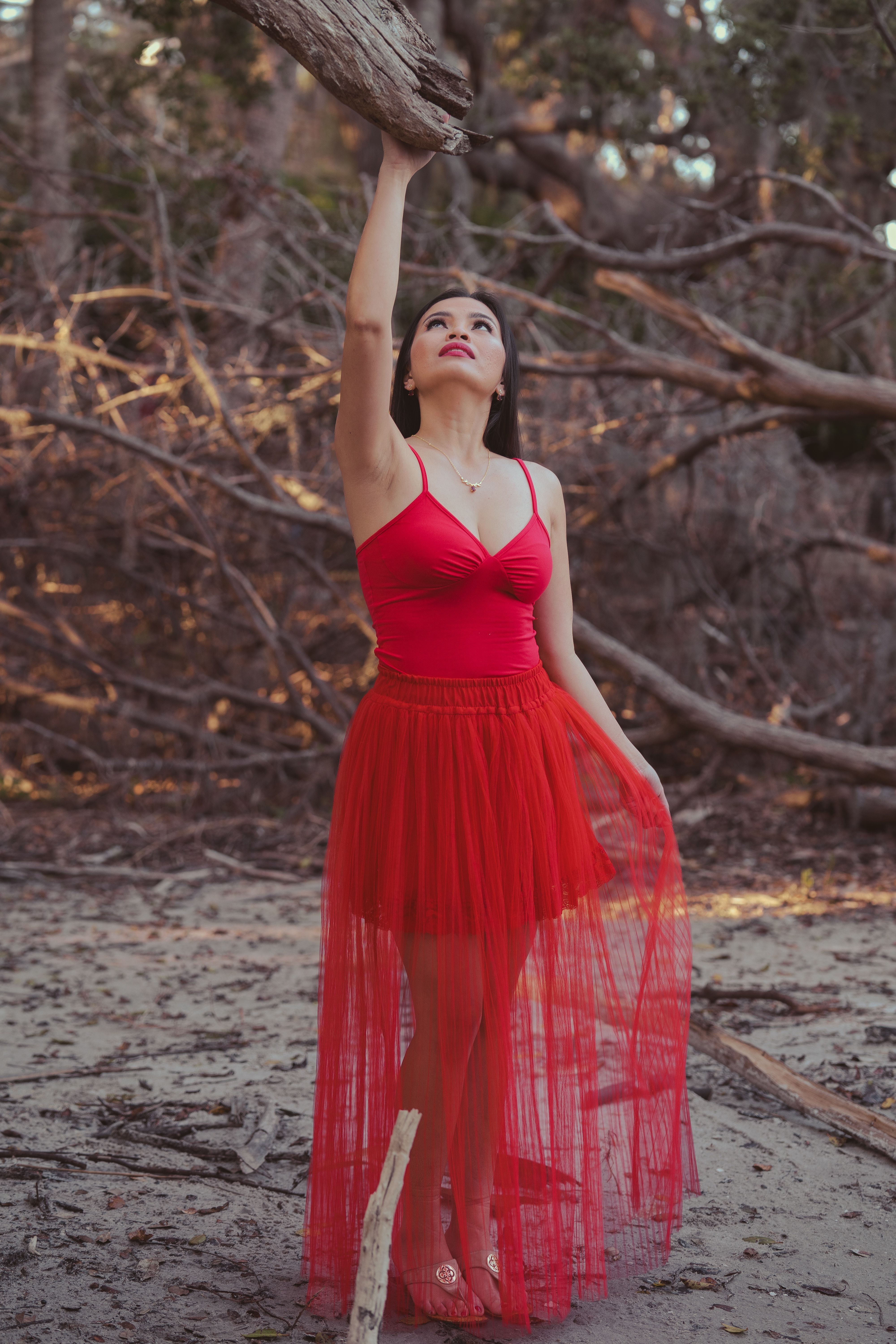 Elegant Woman in Red Dress in Forest Setting · Free Stock Photo