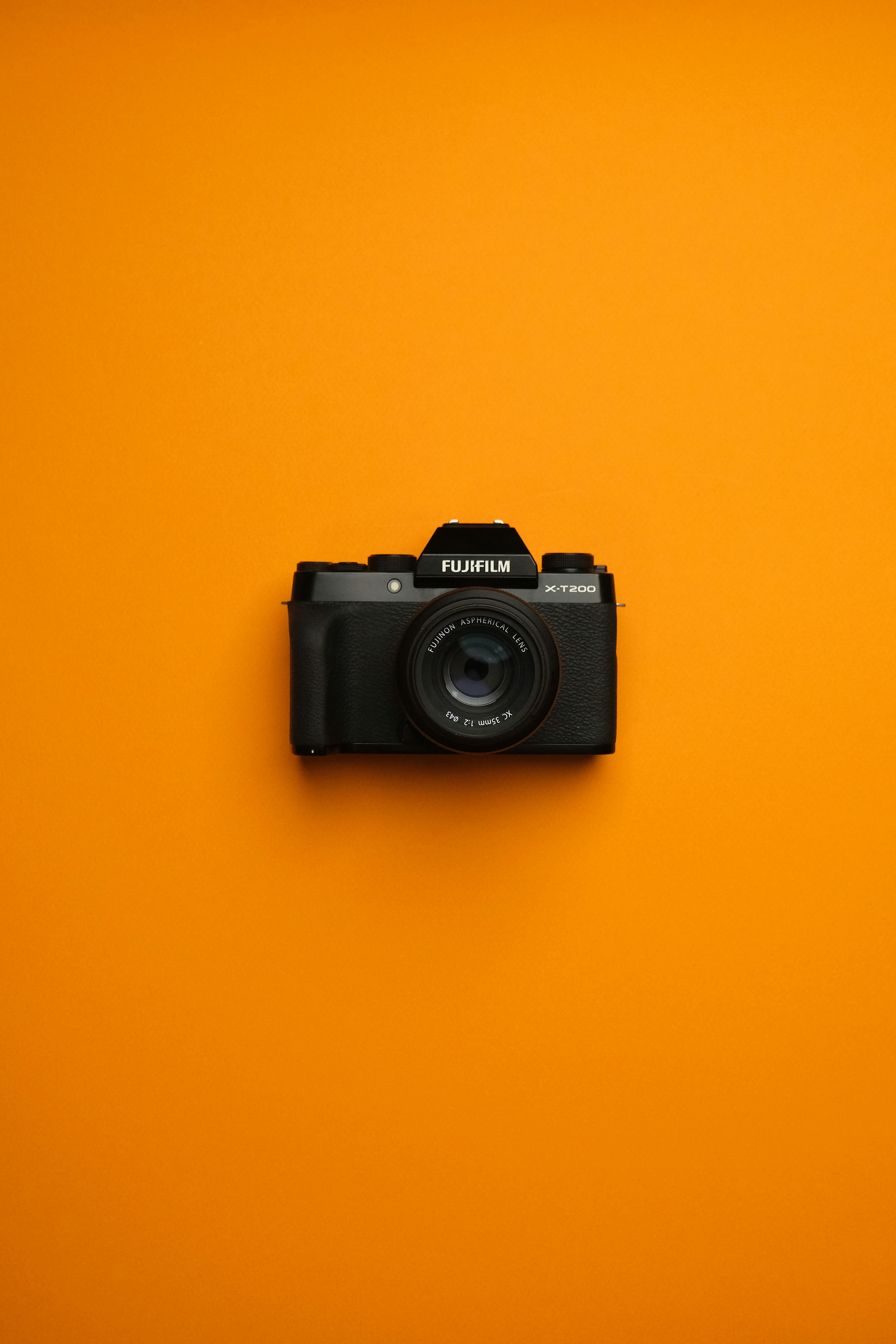 Stylish Fujifilm Camera on Bold Orange Background · Free Stock Photo