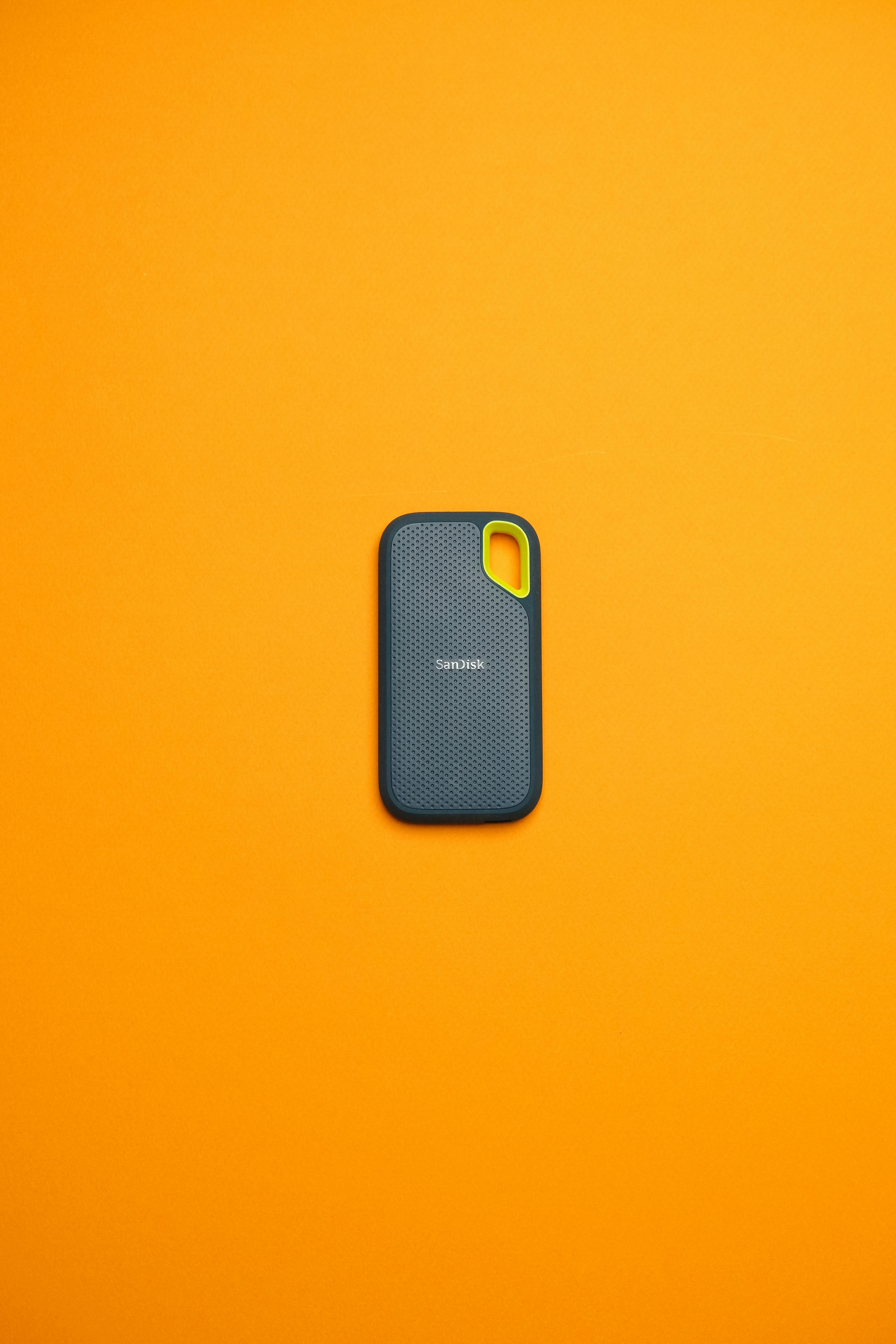Portable SSD on Vibrant Orange Background · Free Stock Photo