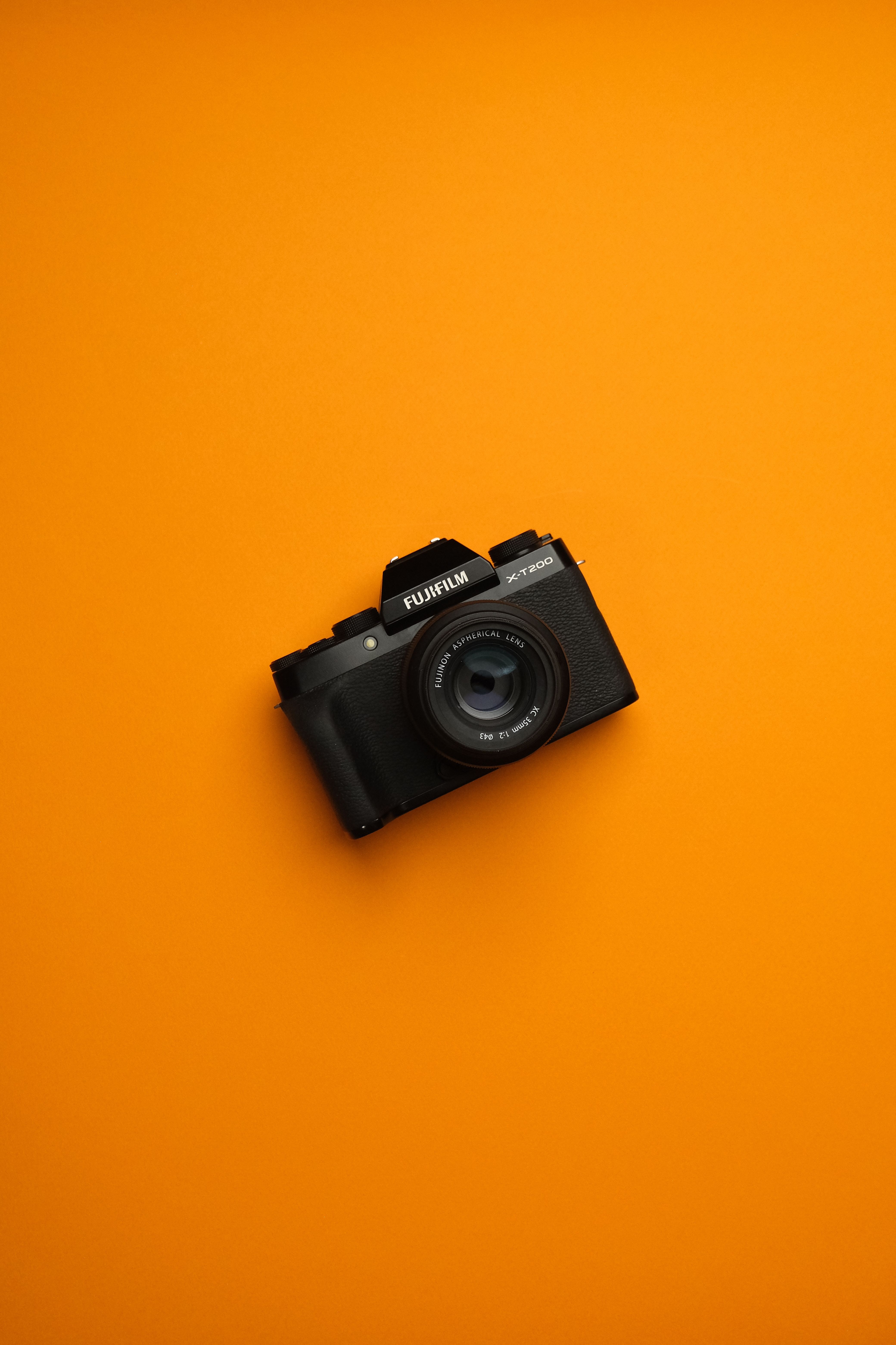 Fujifilm Camera on Vibrant Orange Background · Free Stock Photo