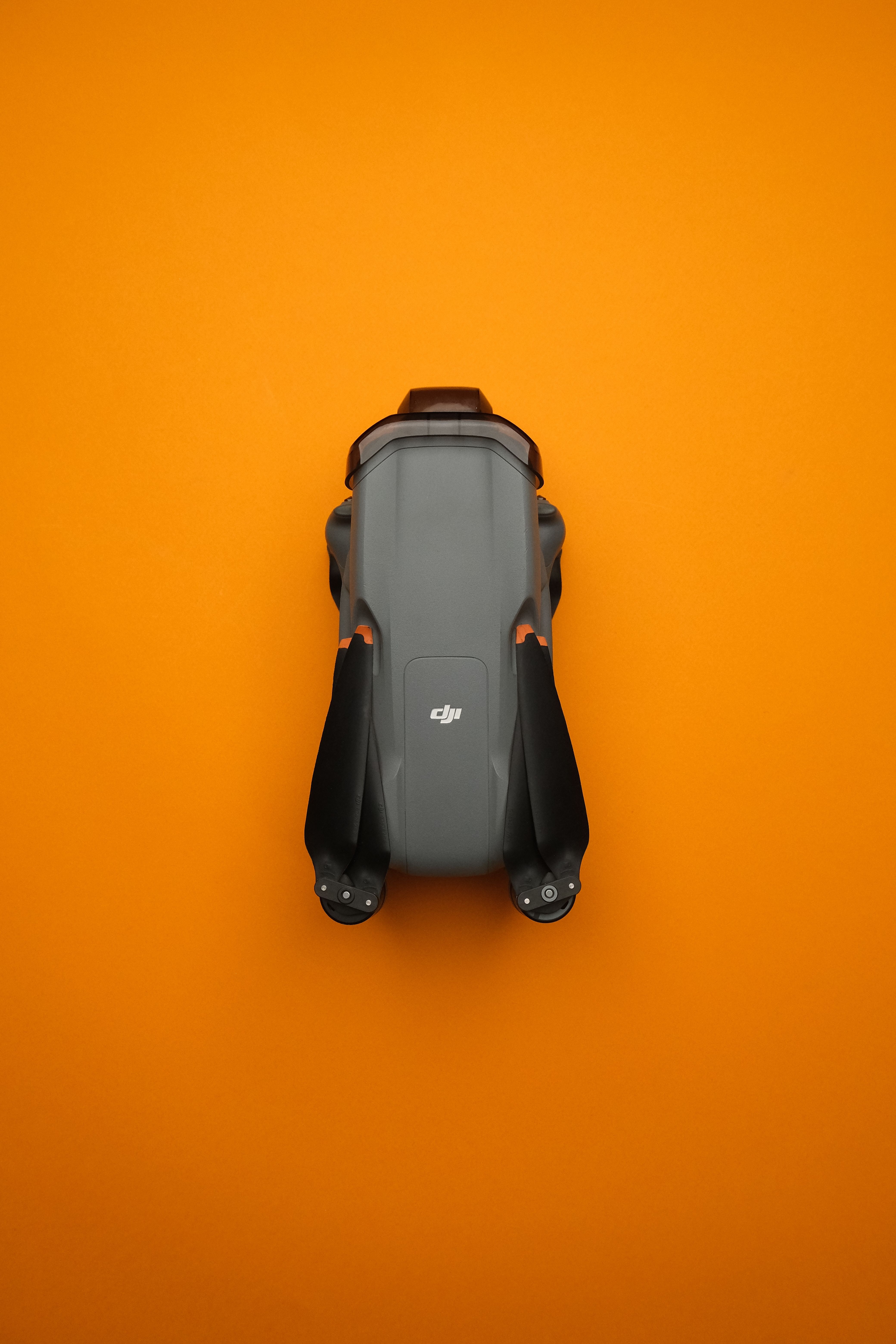 Sleek Gray Drone on Vibrant Orange Background · Free Stock Photo