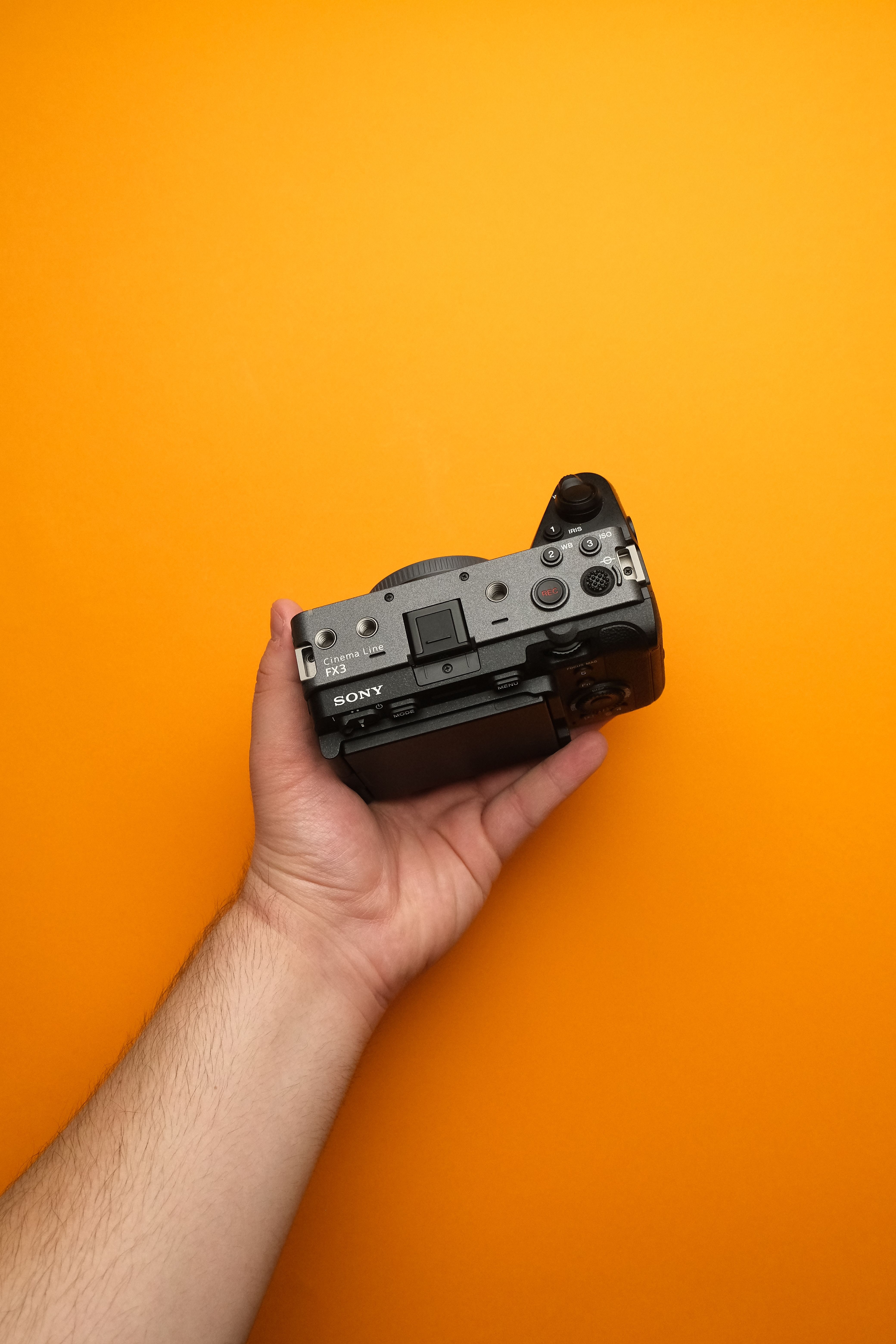 Top View of Handheld Mirrorless Camera on Orange · Free Stock Photo