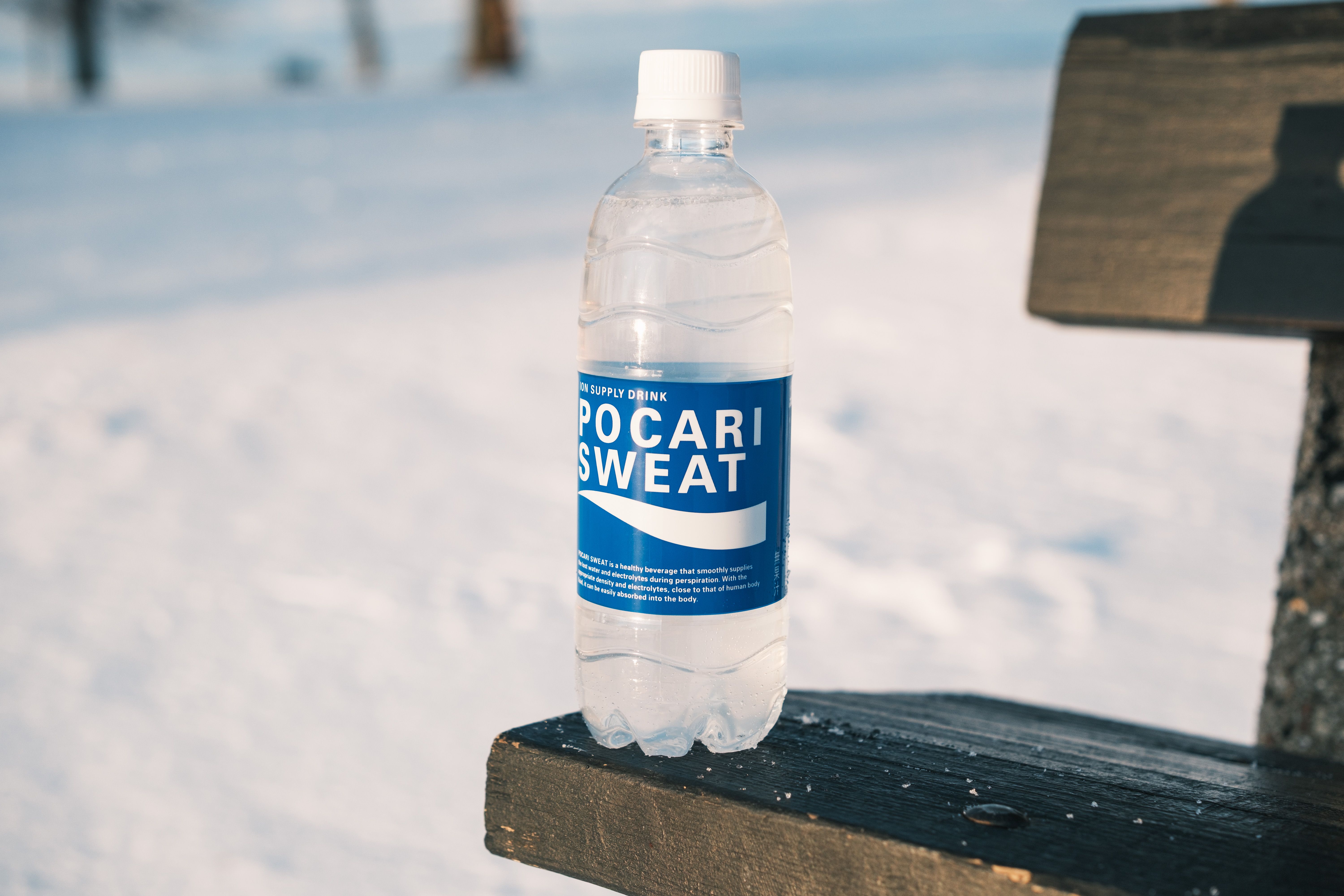 Clear Bottle of Pocari Sweat on Bench in Snow · Free Stock Photo