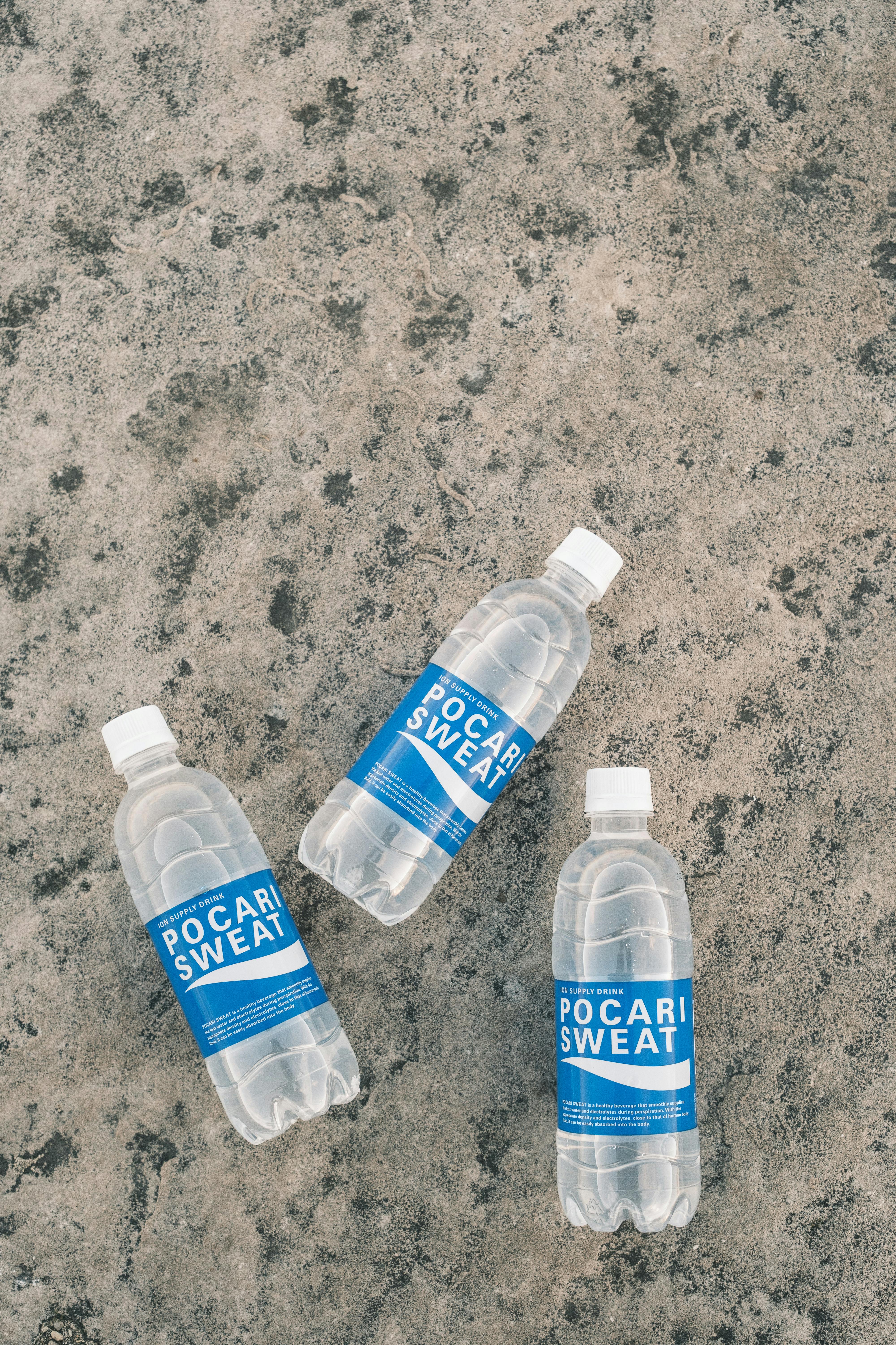 Three Pocari Sweat Bottles on Textured Surface · Free Stock Photo
