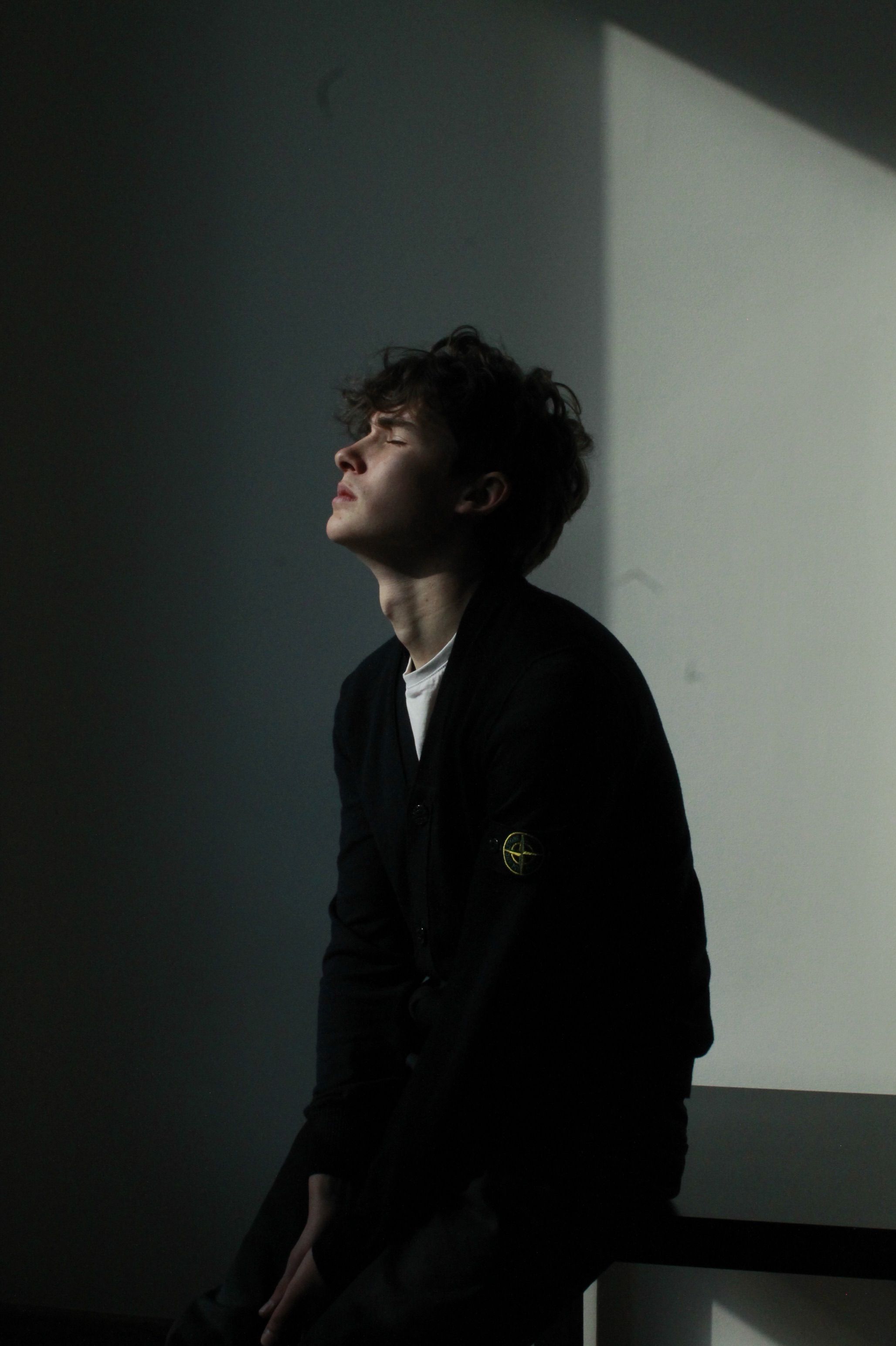 Contemplative Young Man in Dramatic Shadow · Free Stock Photo