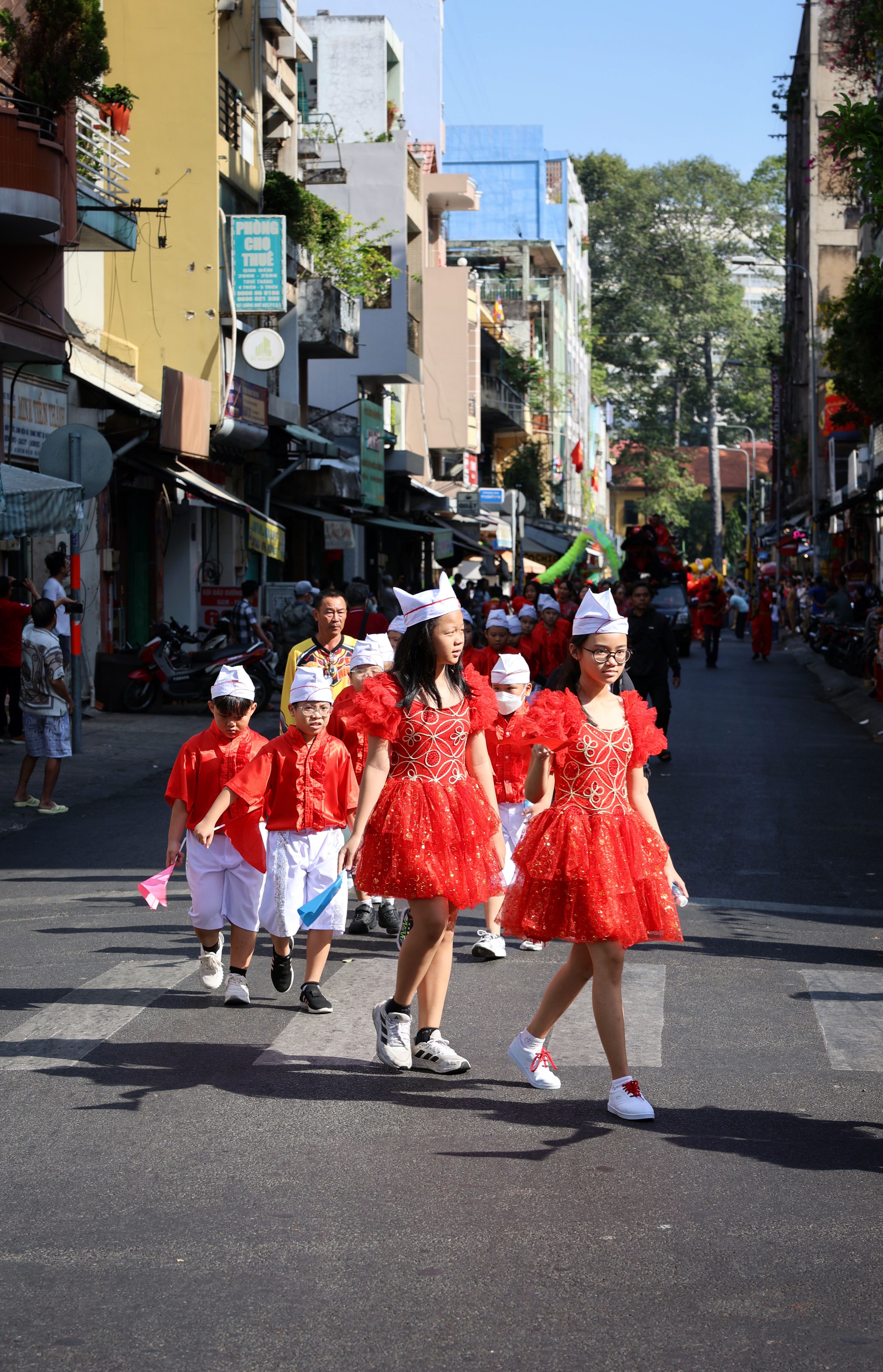 Vibrant Parade with Children in Red Costumes · Free Stock Photo