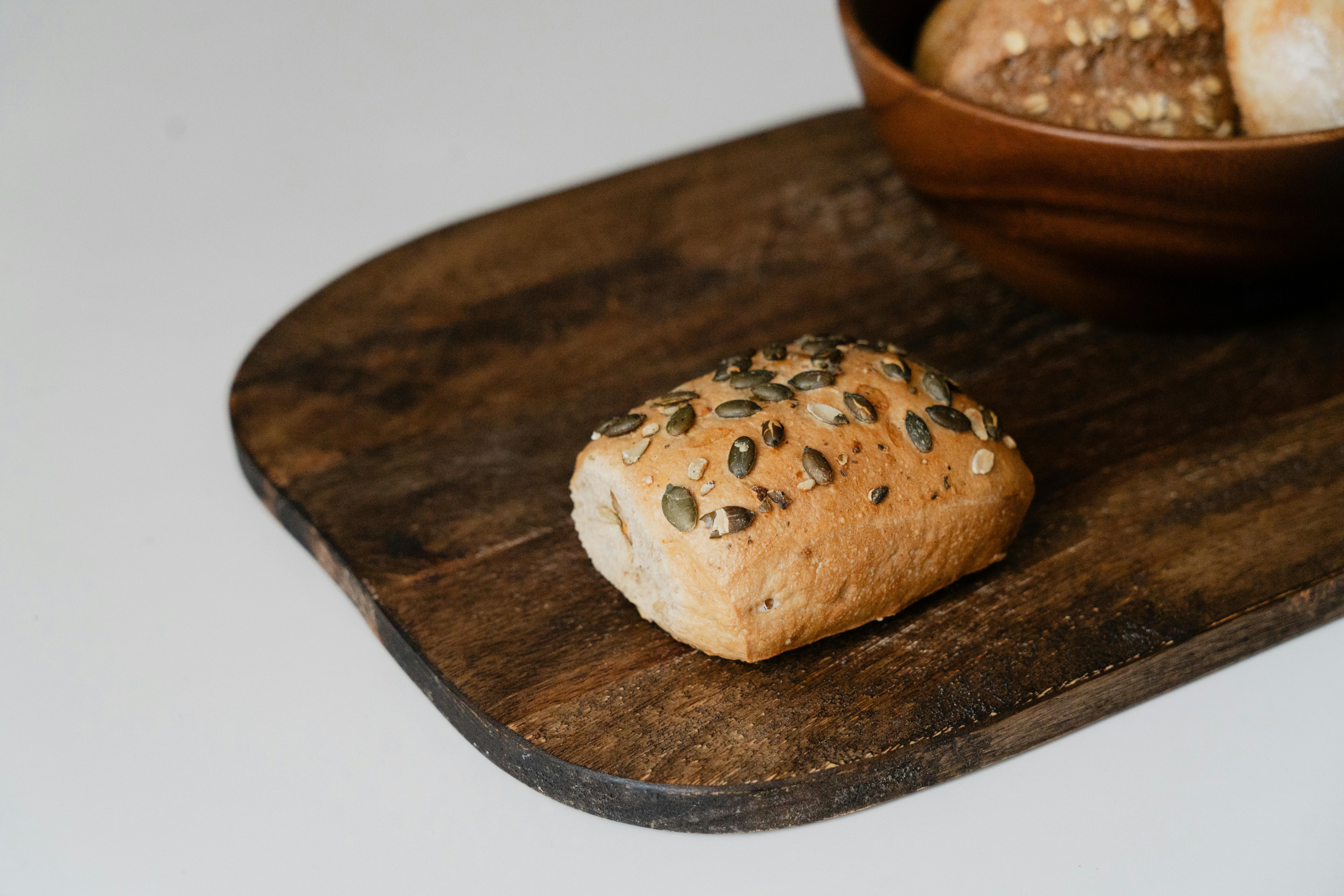 Rustic Seeded Bread Roll on Wooden Board · Free Stock Photo