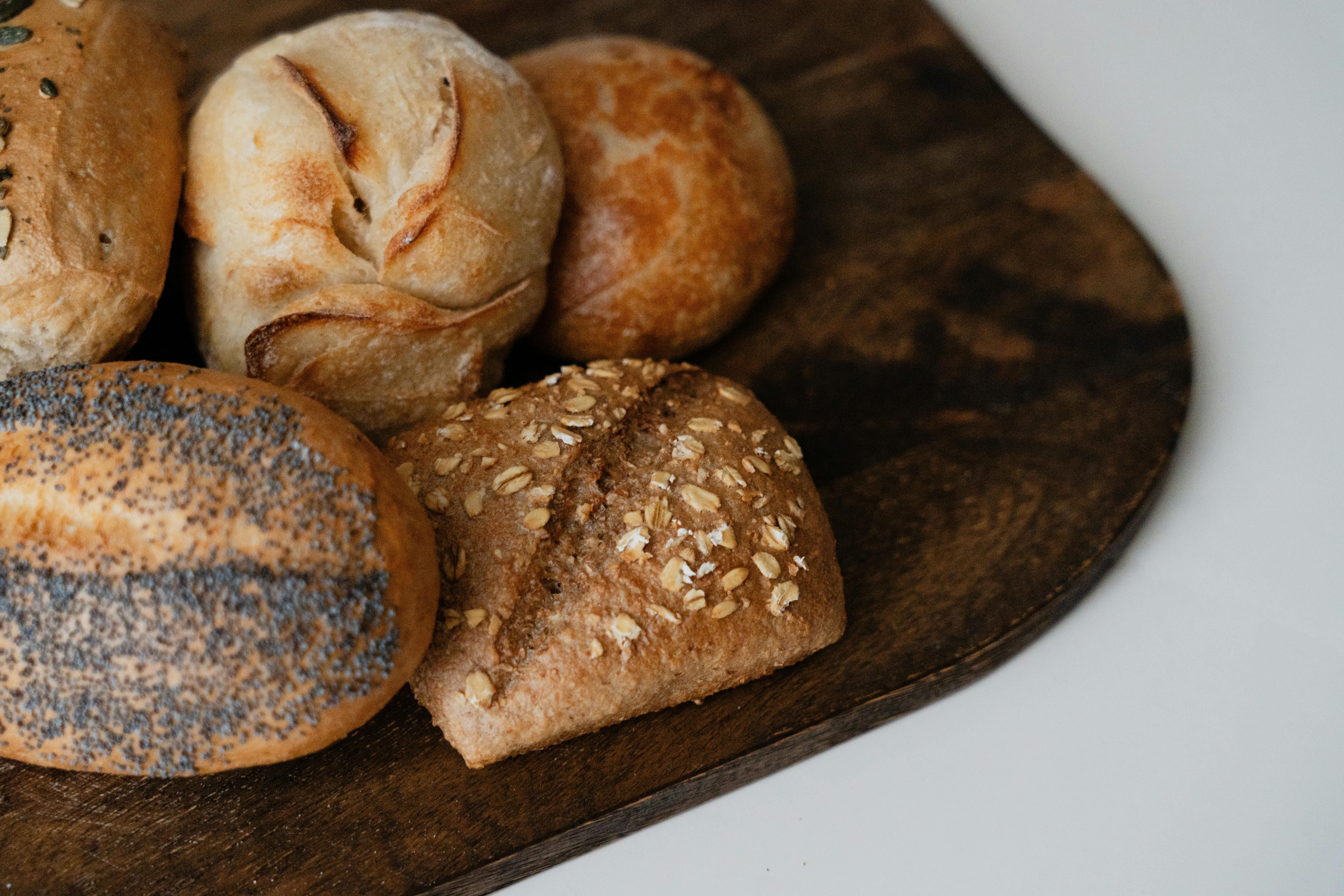 Assorted Artisan Bread Rolls on Wooden Board · Free Stock Photo