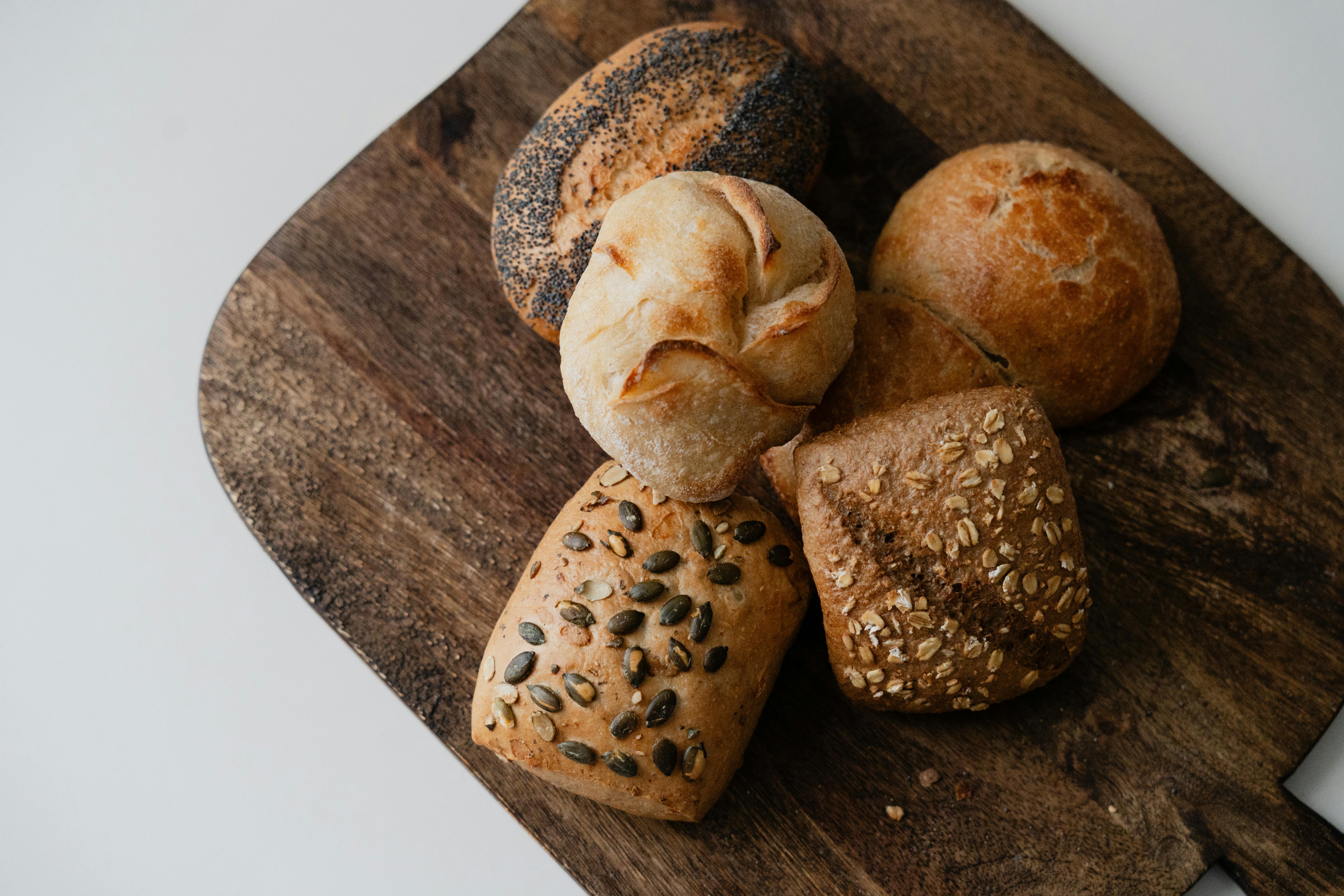 Assorted Artisan Bread Rolls on Wooden Board · Free Stock Photo