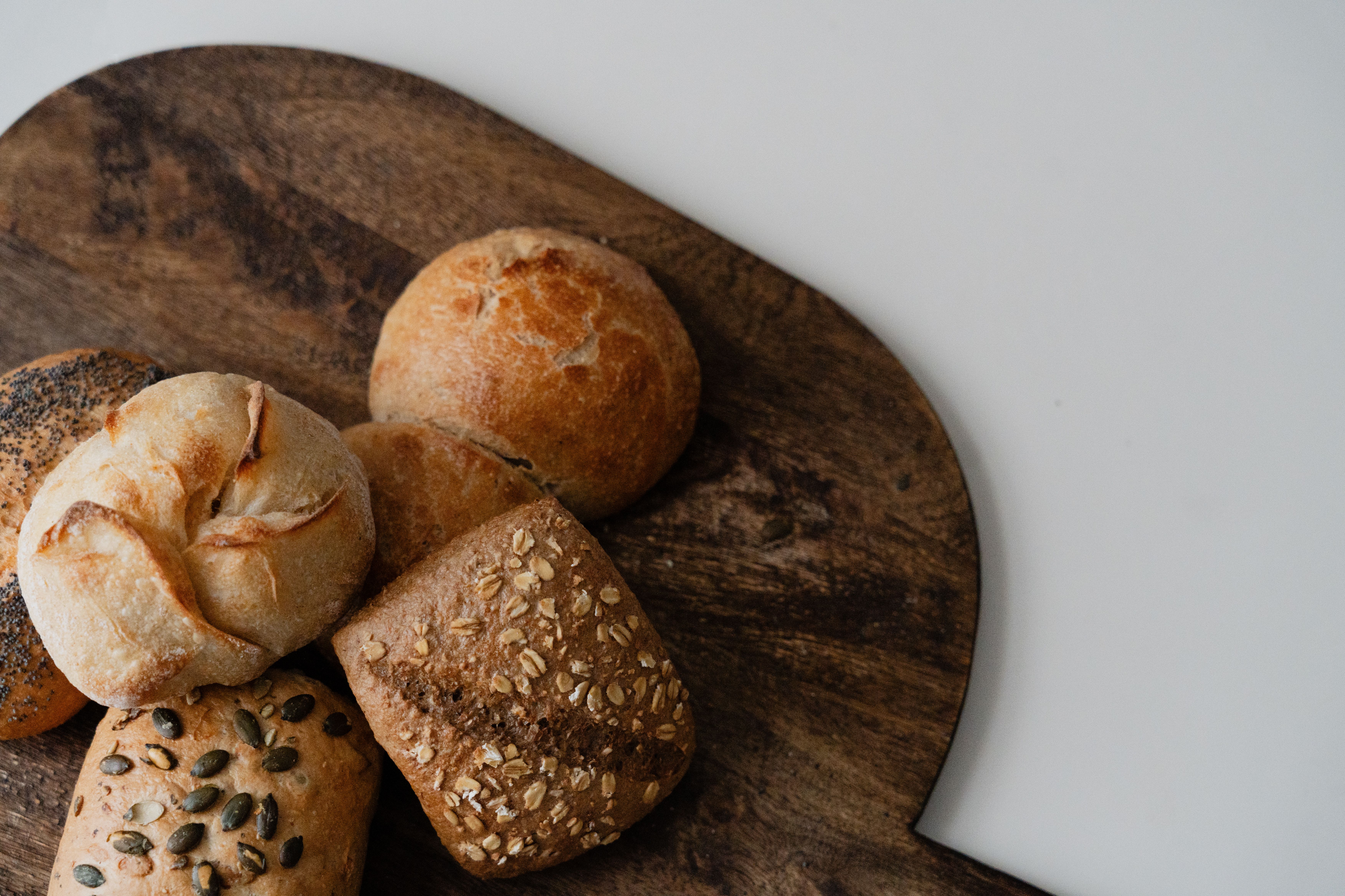 Assorted Artisan Bread Rolls on Wooden Board · Free Stock Photo