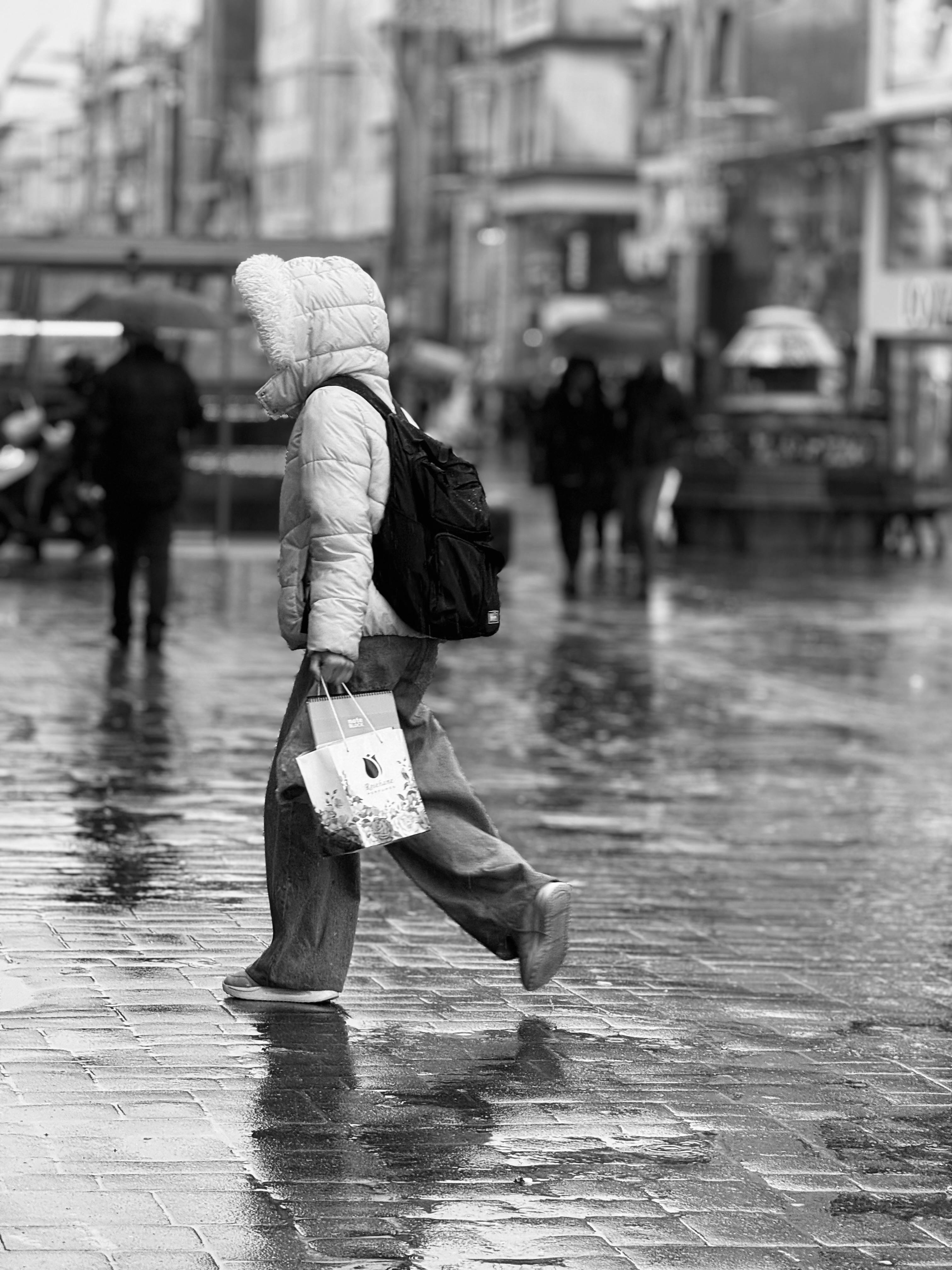 Urban street scene with person walking on rainy day · Free Stock Photo