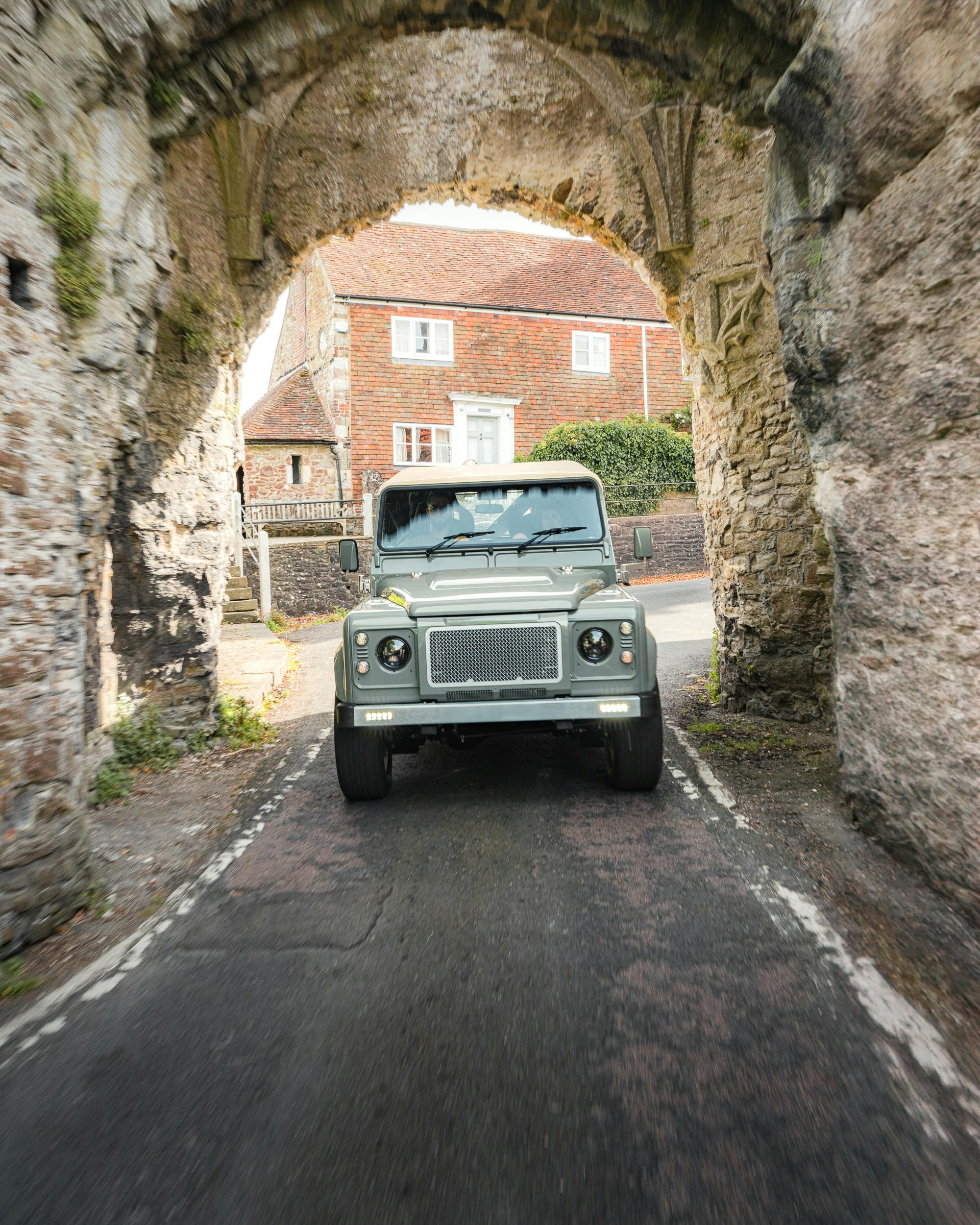 Vintage Land Rover on Rustic Stone Arch Road · Free Stock Photo