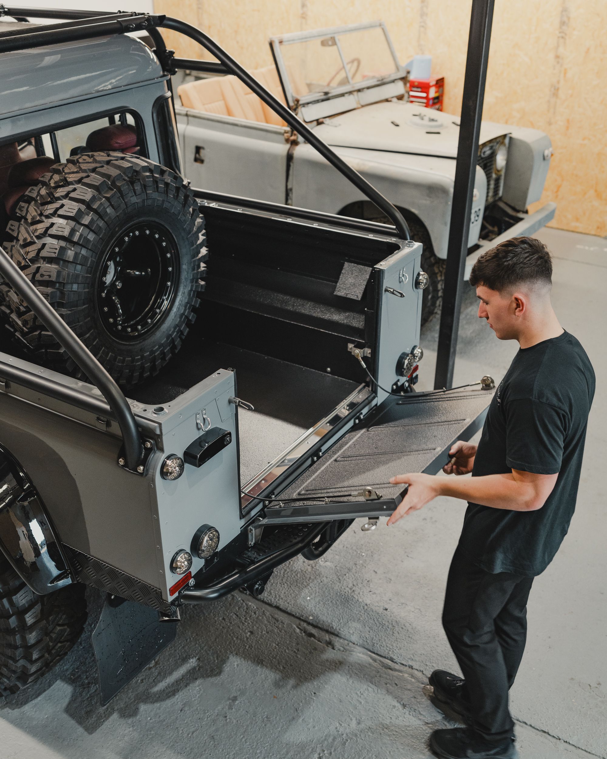 Man Inspecting Off-Road Vehicle in Workshop · Free Stock Photo