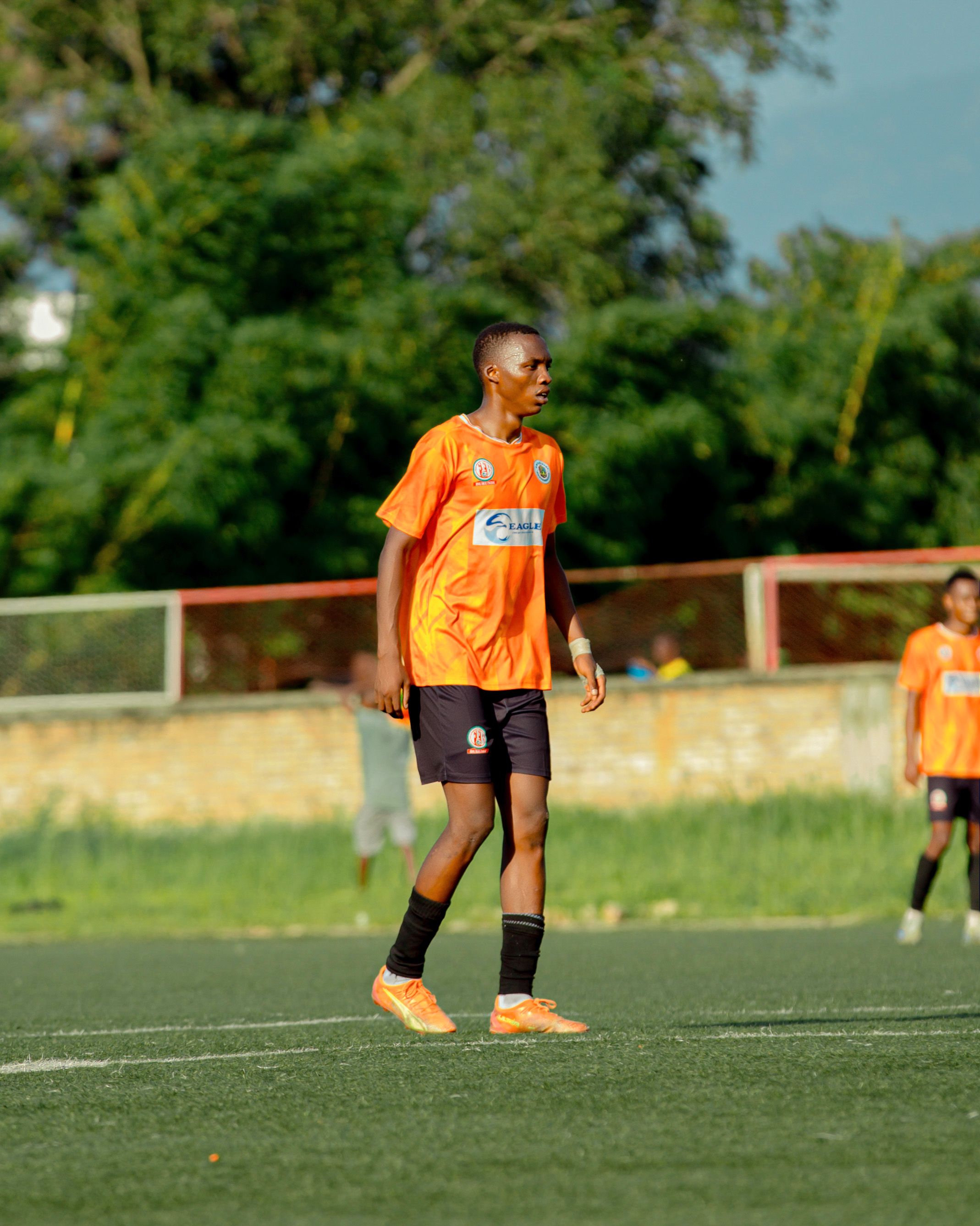 Young Athlete Playing Soccer in Orange Jersey · Free Stock Photo