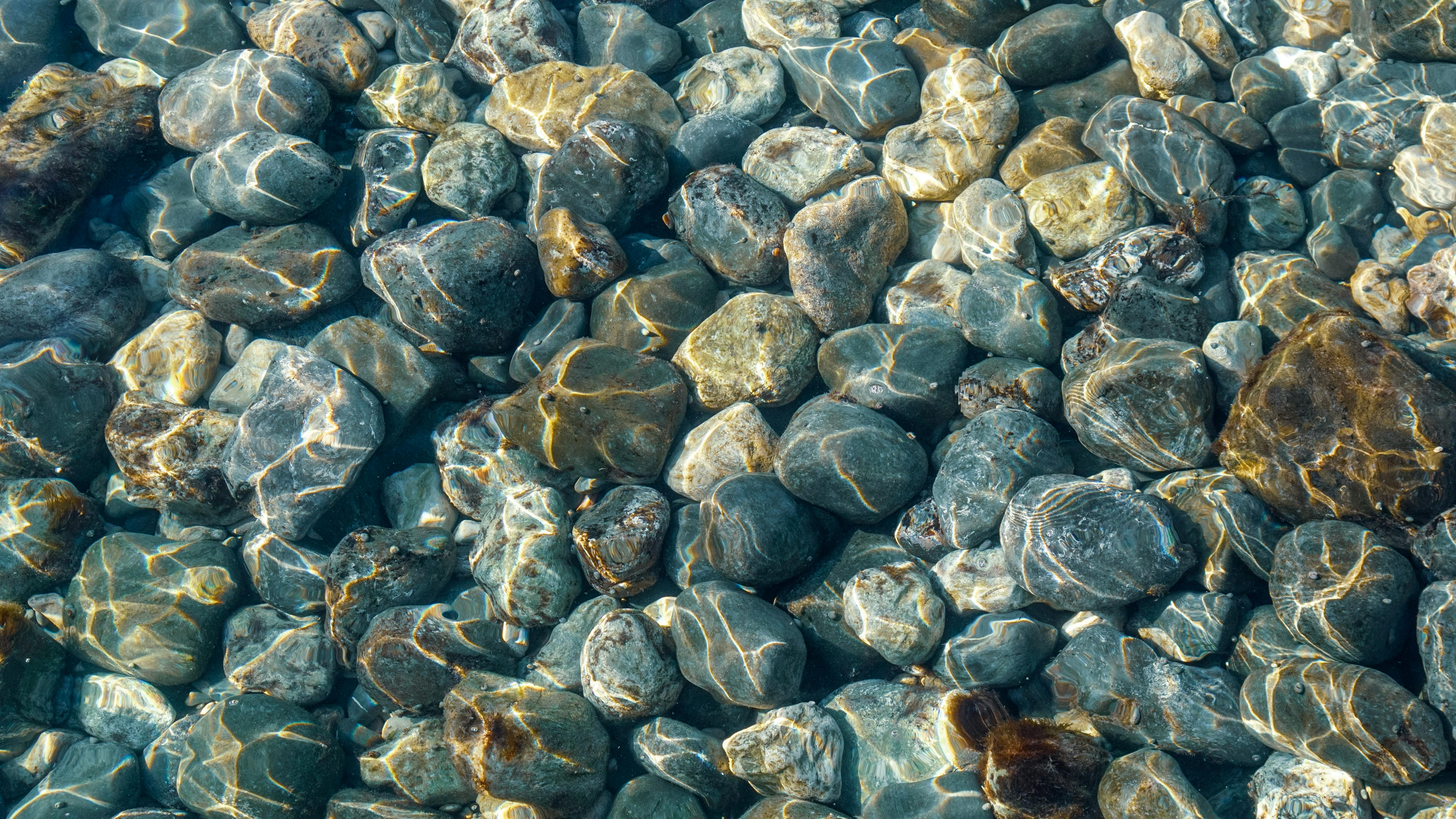 Close-Up of Sunlit Pebbles Underwater · Free Stock Photo
