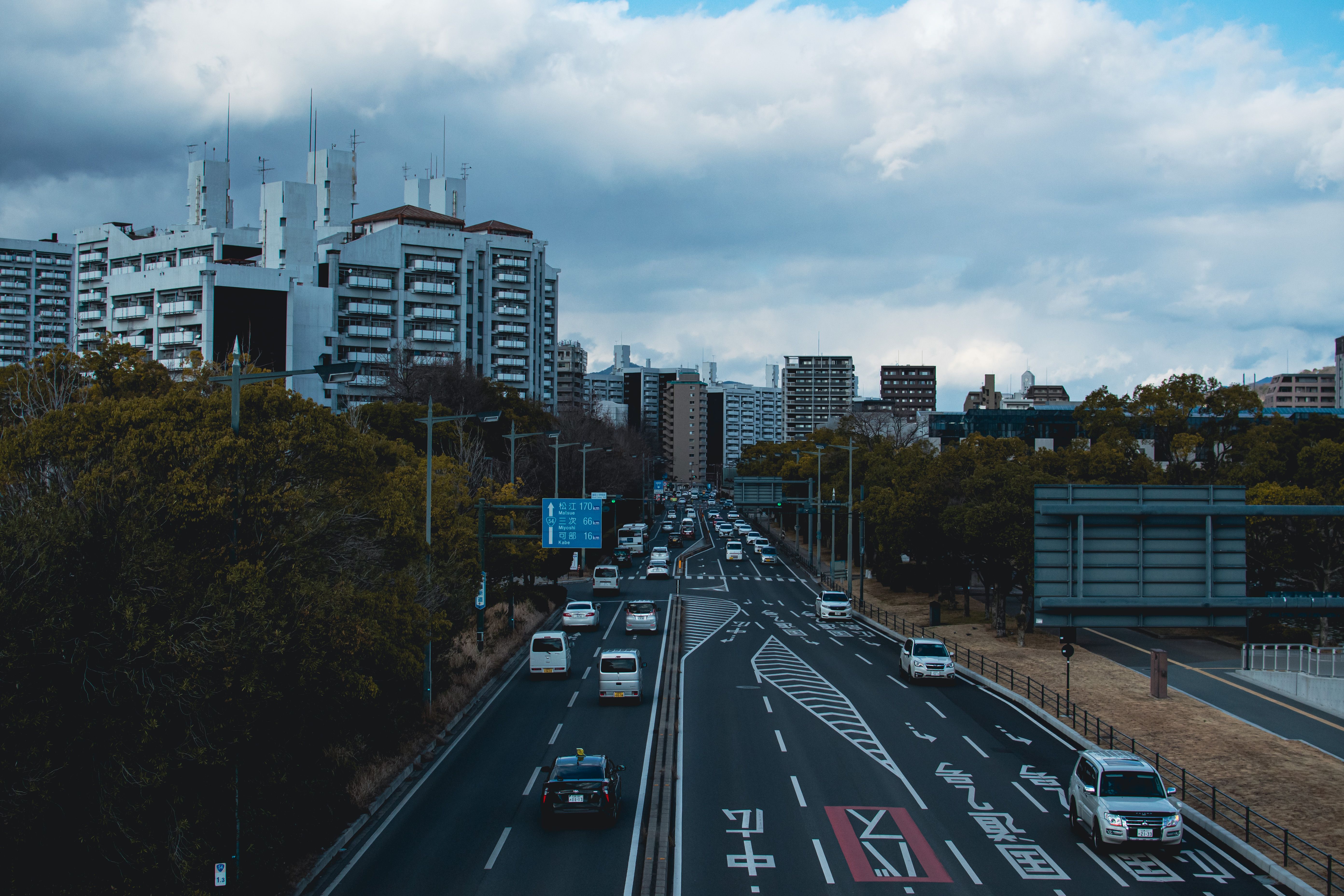 Urban Street Scene with Traffic and Cloudy Sky · Free Stock Photo