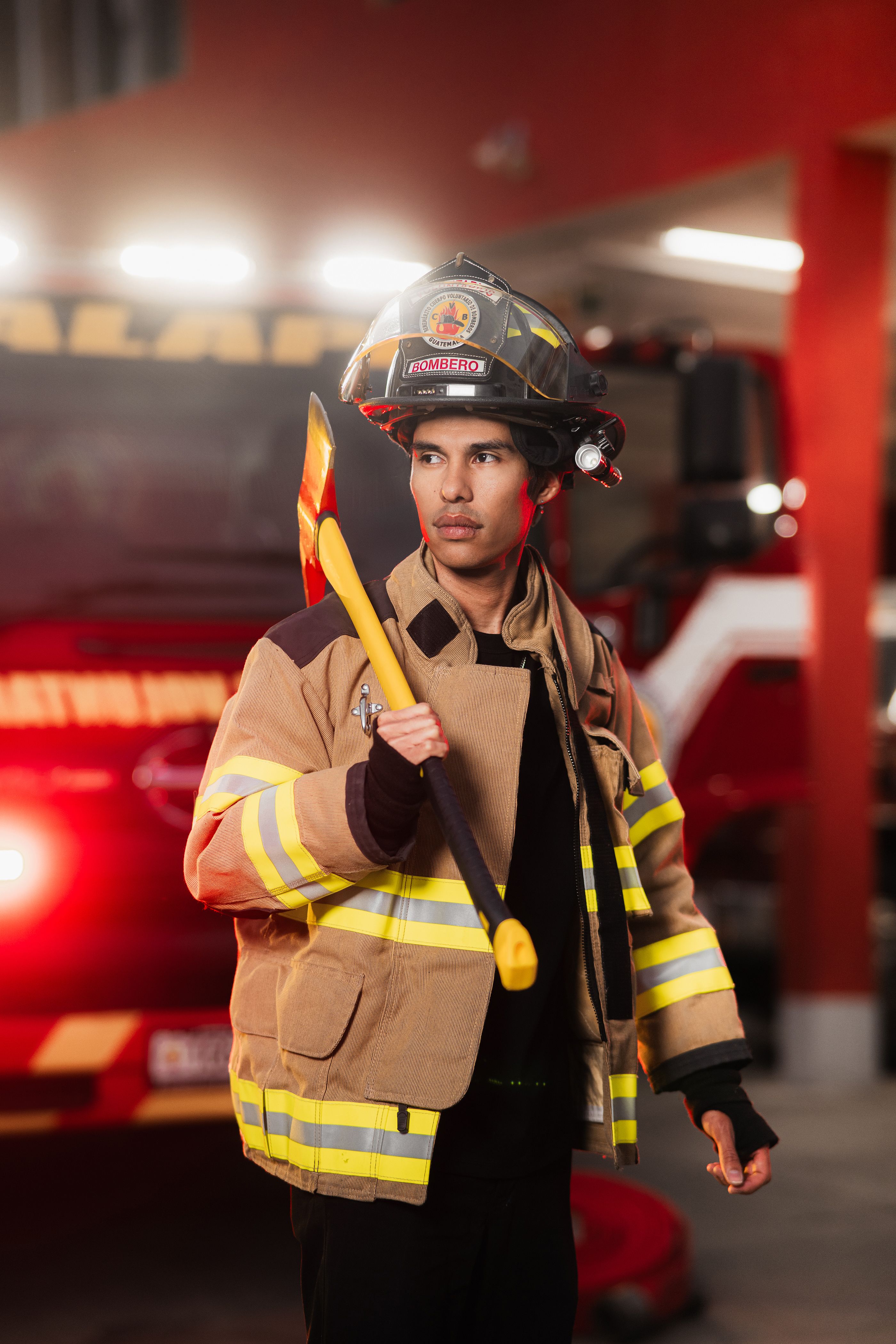 Professional Firefighter Holding Axe in Fire Station · Free Stock Photo