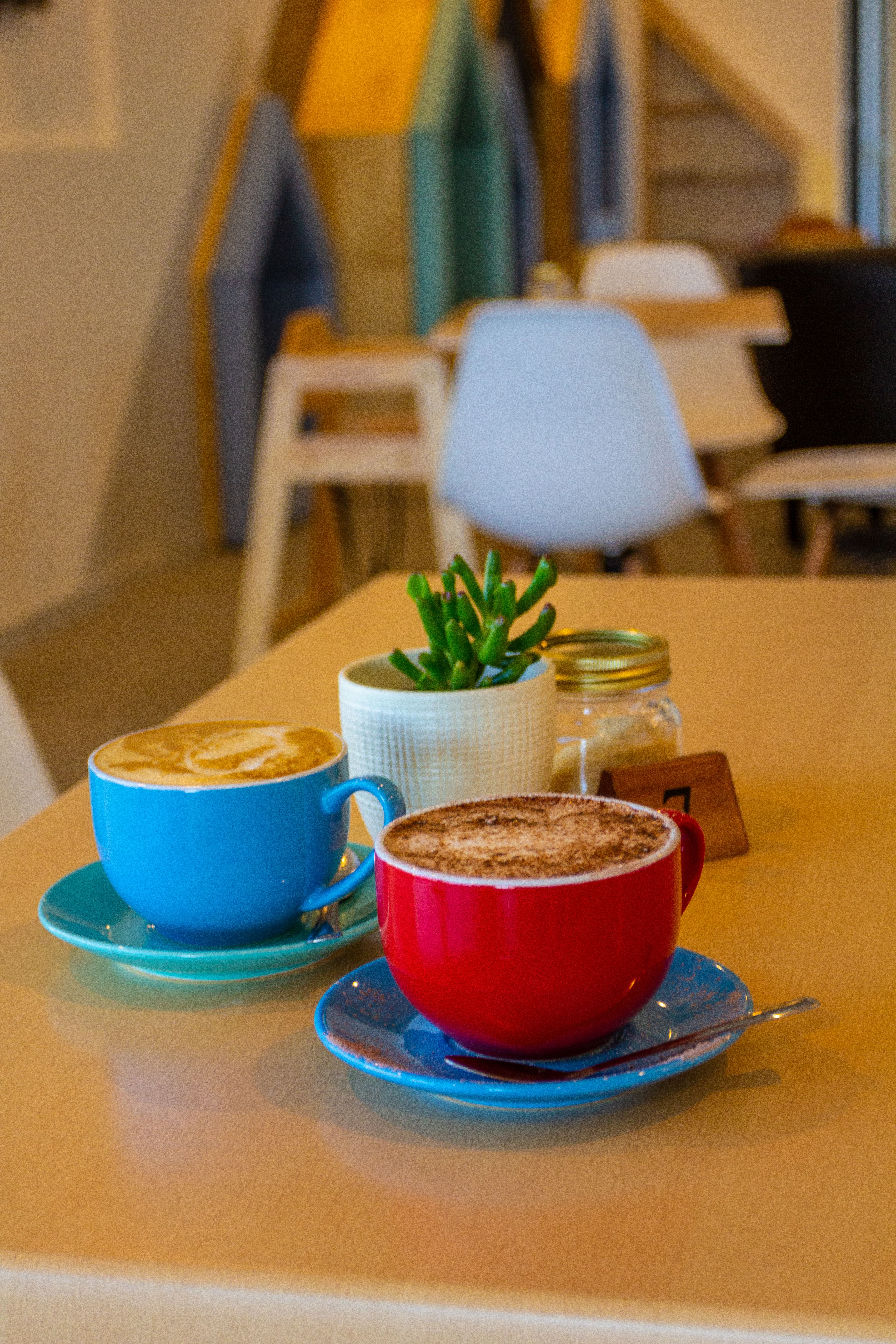 Colorful Coffee Cups in a Modern Café Setting · Free Stock Photo