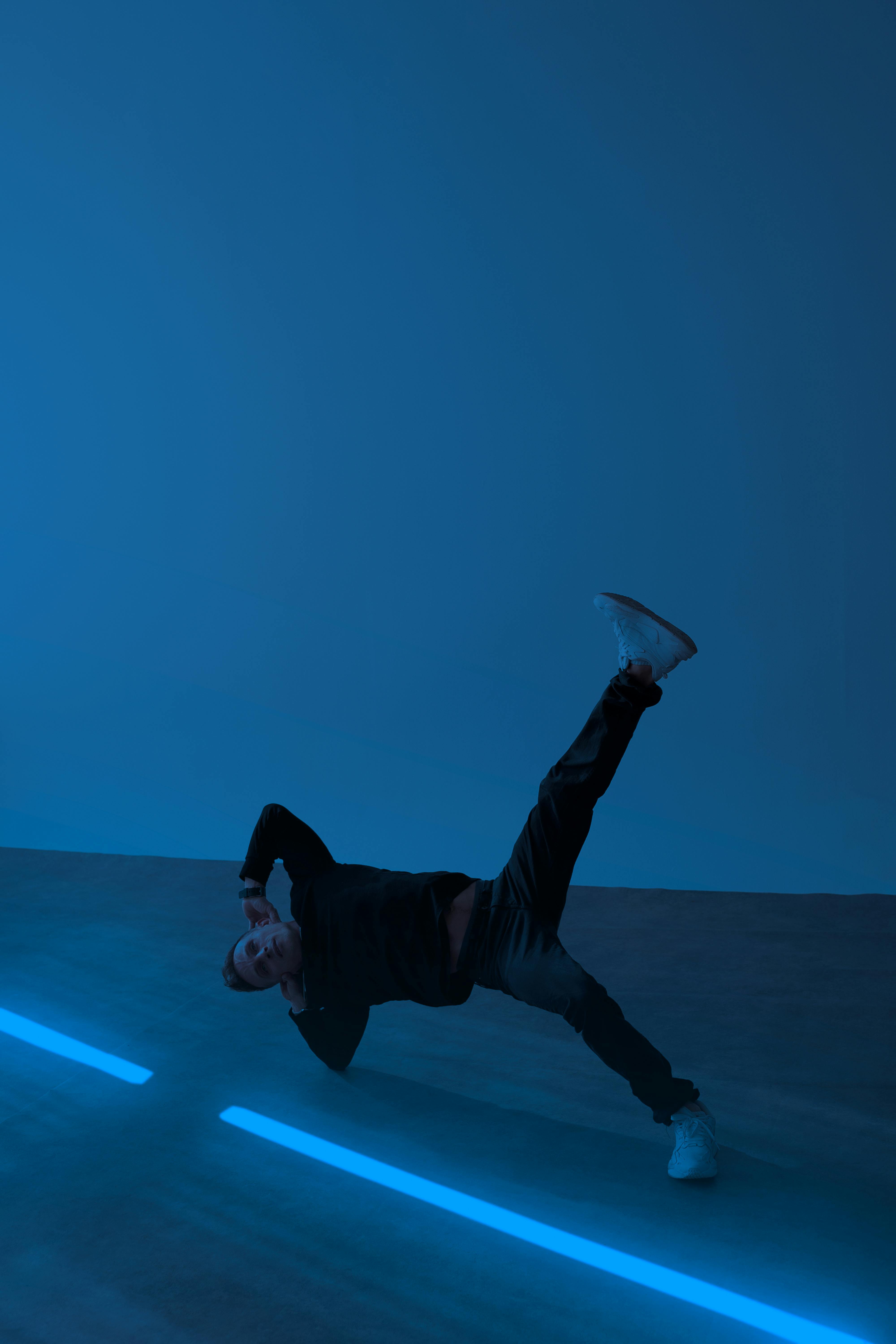 Dynamic Dance Pose with Blue Neon Lights · Free Stock Photo