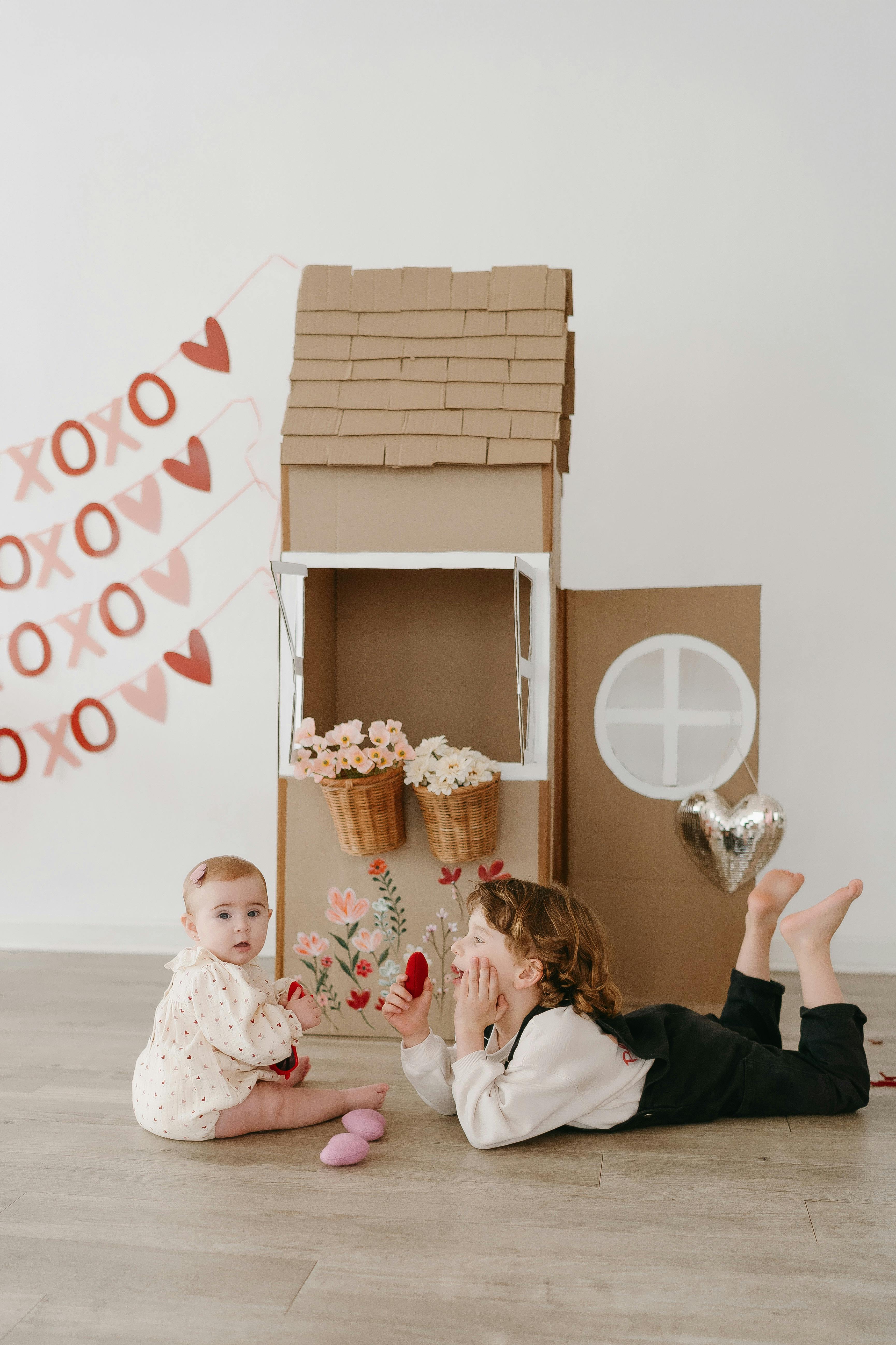 Children Playing in a Cardboard House Setup · Free Stock Photo