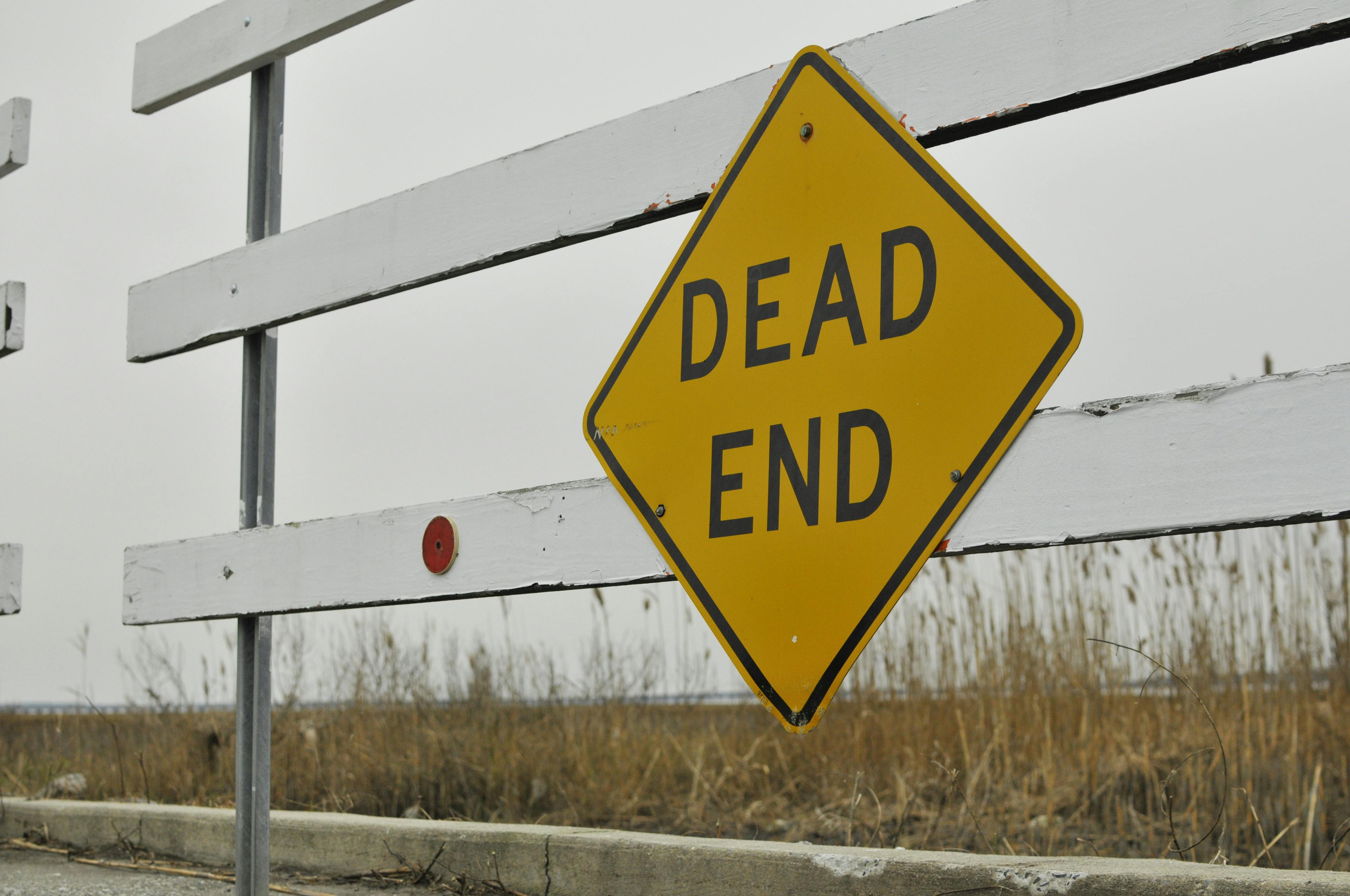 Yellow Dead End sign with white wooden fence · Free Stock Photo
