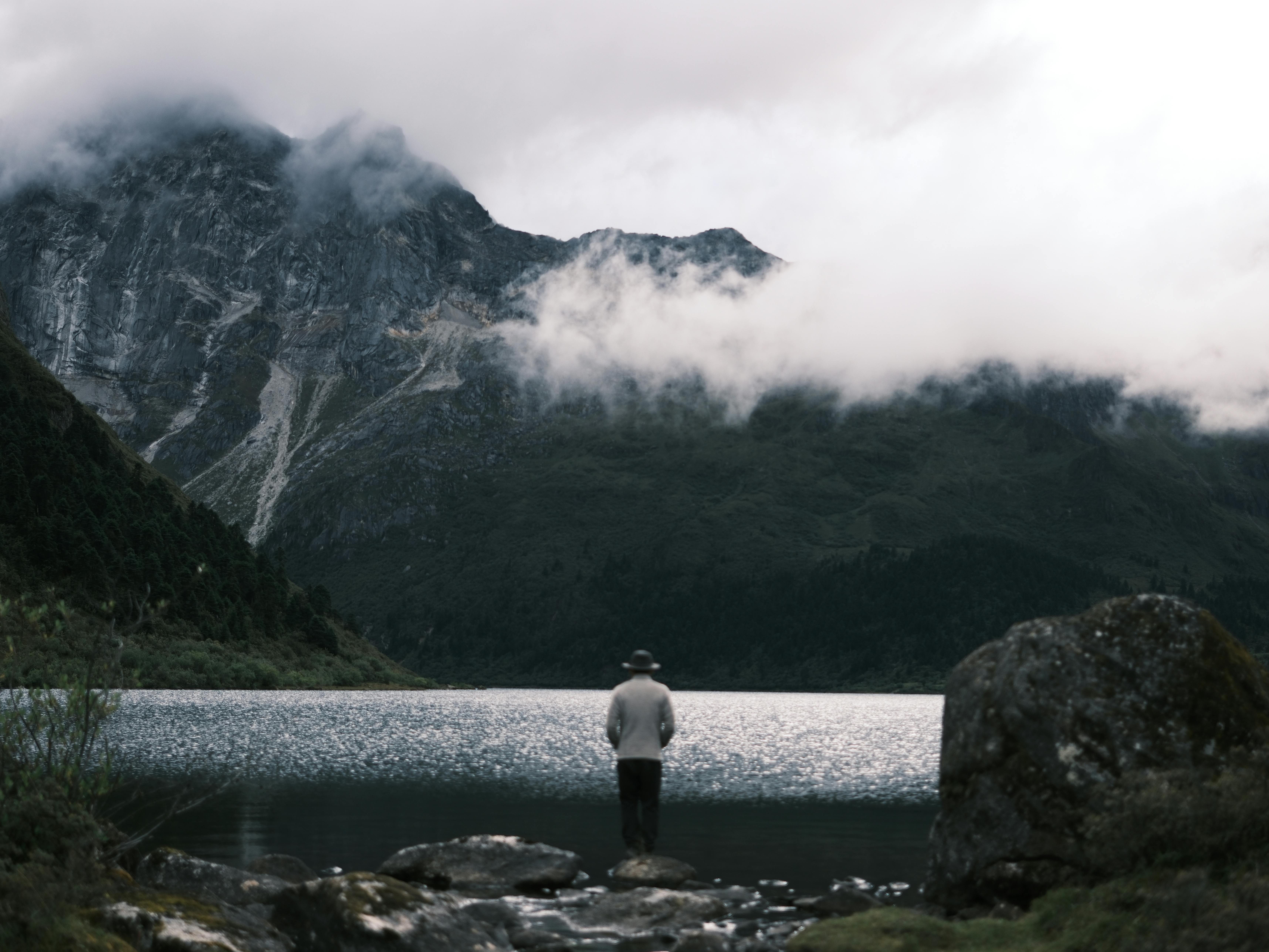 Solitary Figure by Mountainous Lakeside · Free Stock Photo