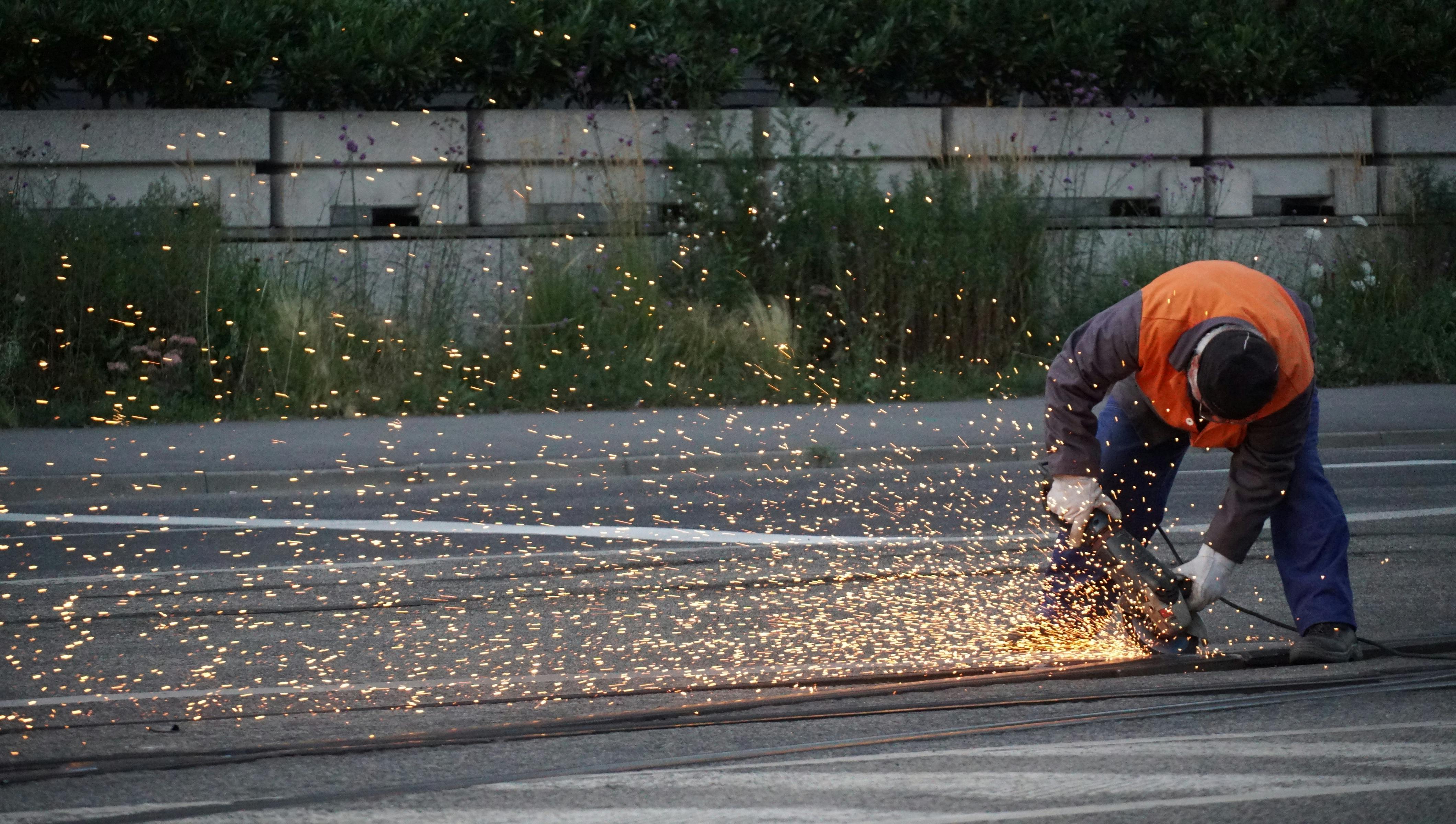 Railway Worker Cutting Tracks with Sparks Flying · Free Stock Photo