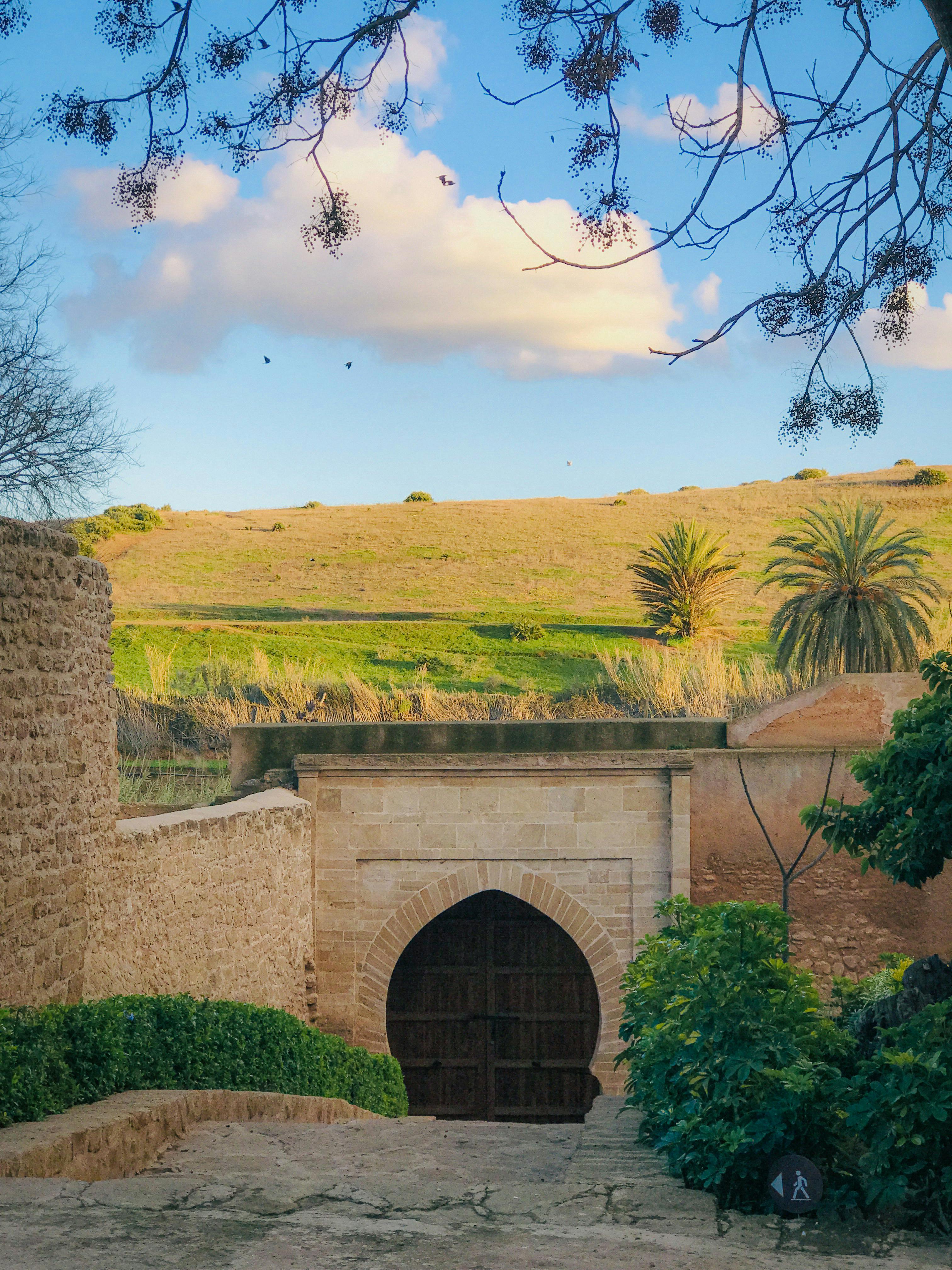 Historic Moroccan Gate in Rabat's Lush Landscape · Free Stock Photo