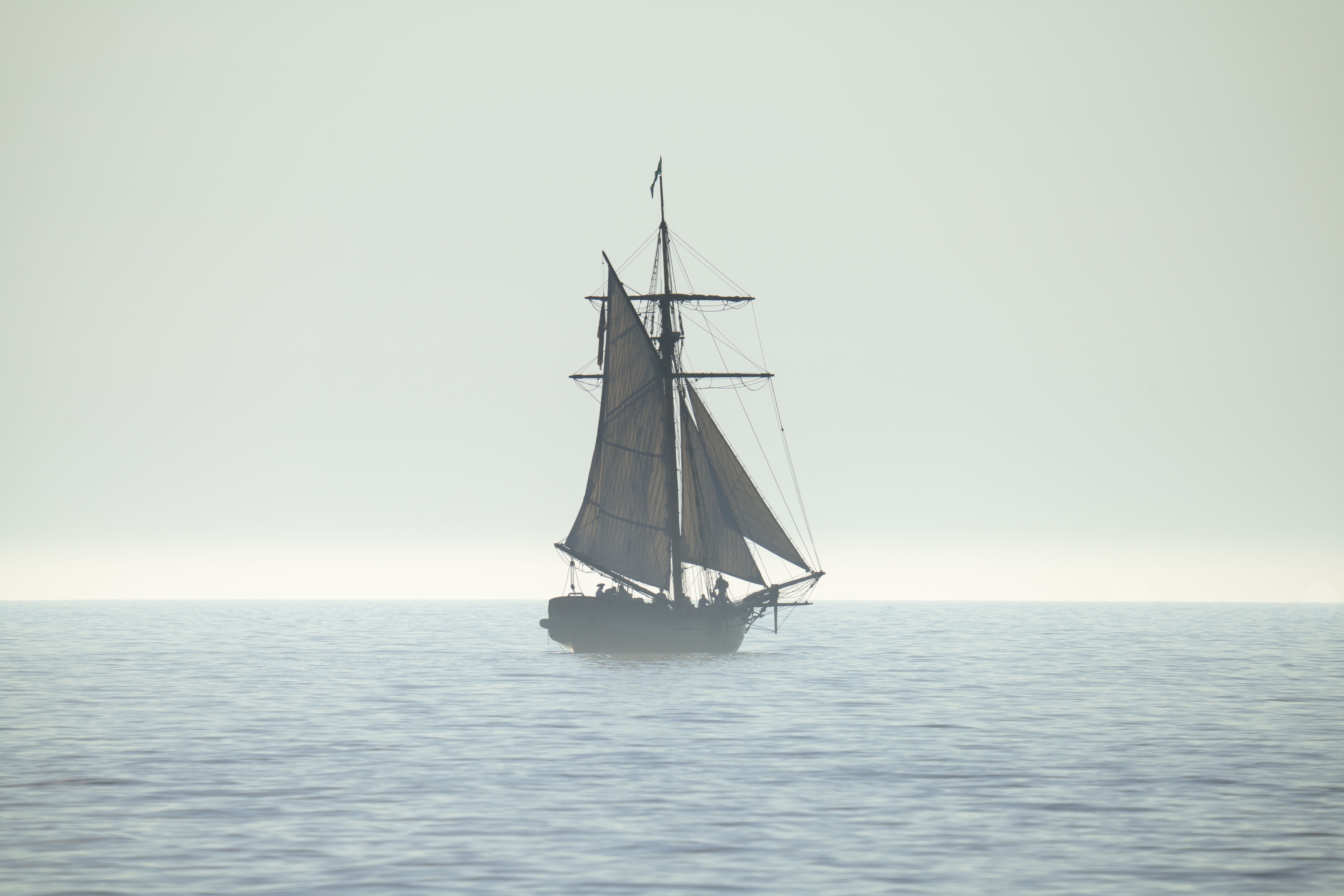 Serene Sailing Ship Silhouette on Calm Sea · Free Stock Photo