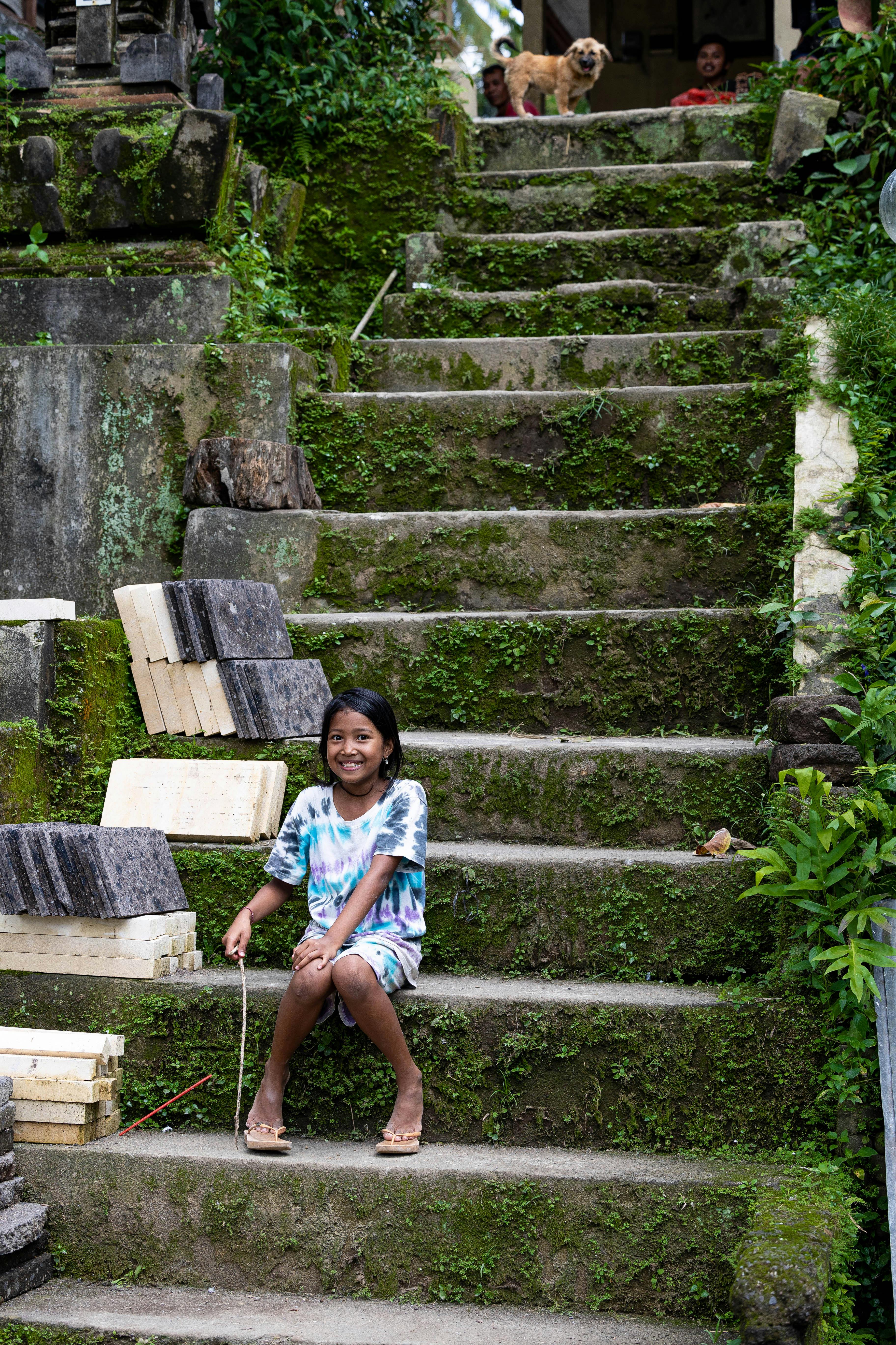 Smiling Child on Mossy Stairs in Bali · Free Stock Photo