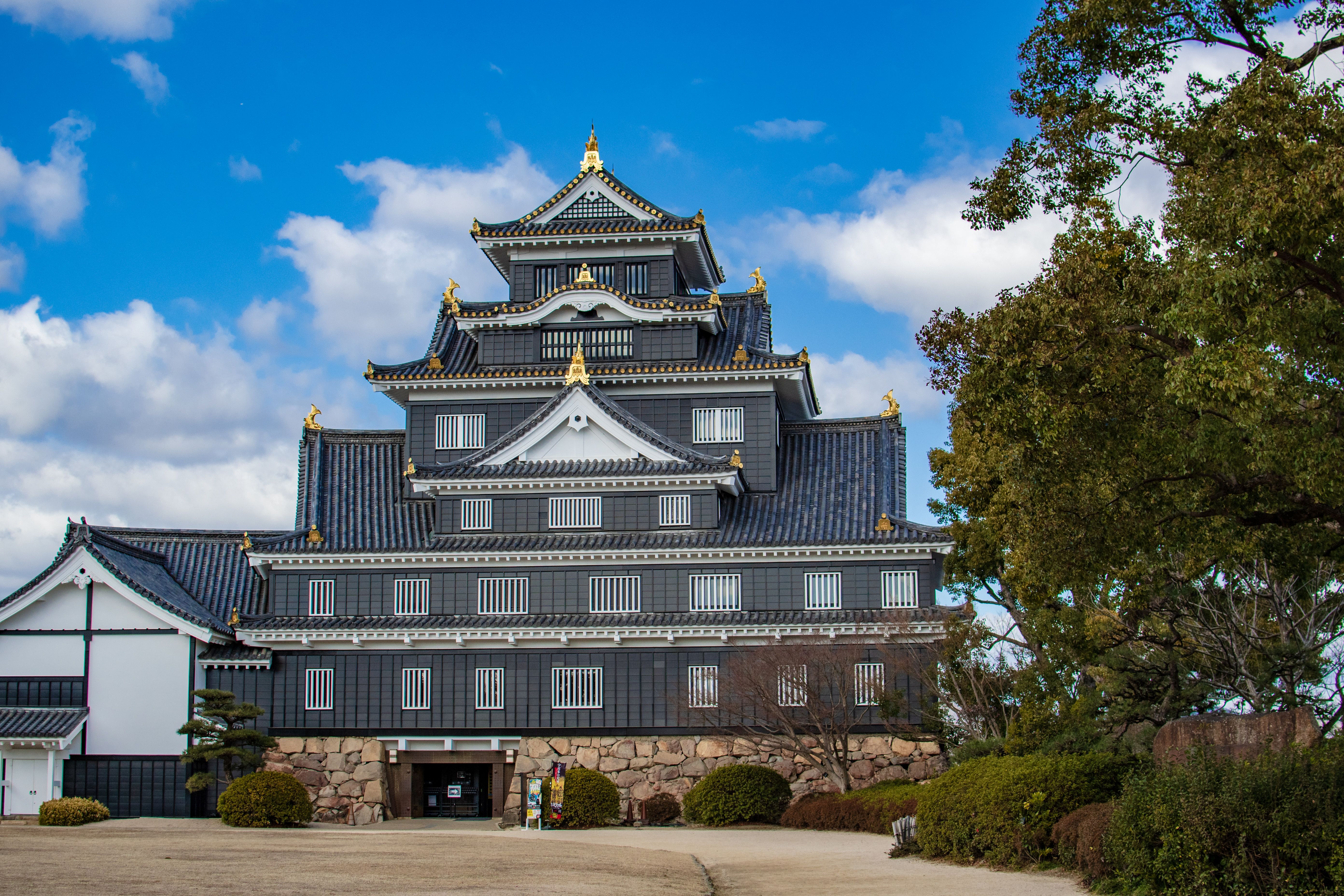 Okayama Castle under a vibrant blue sky · Free Stock Photo