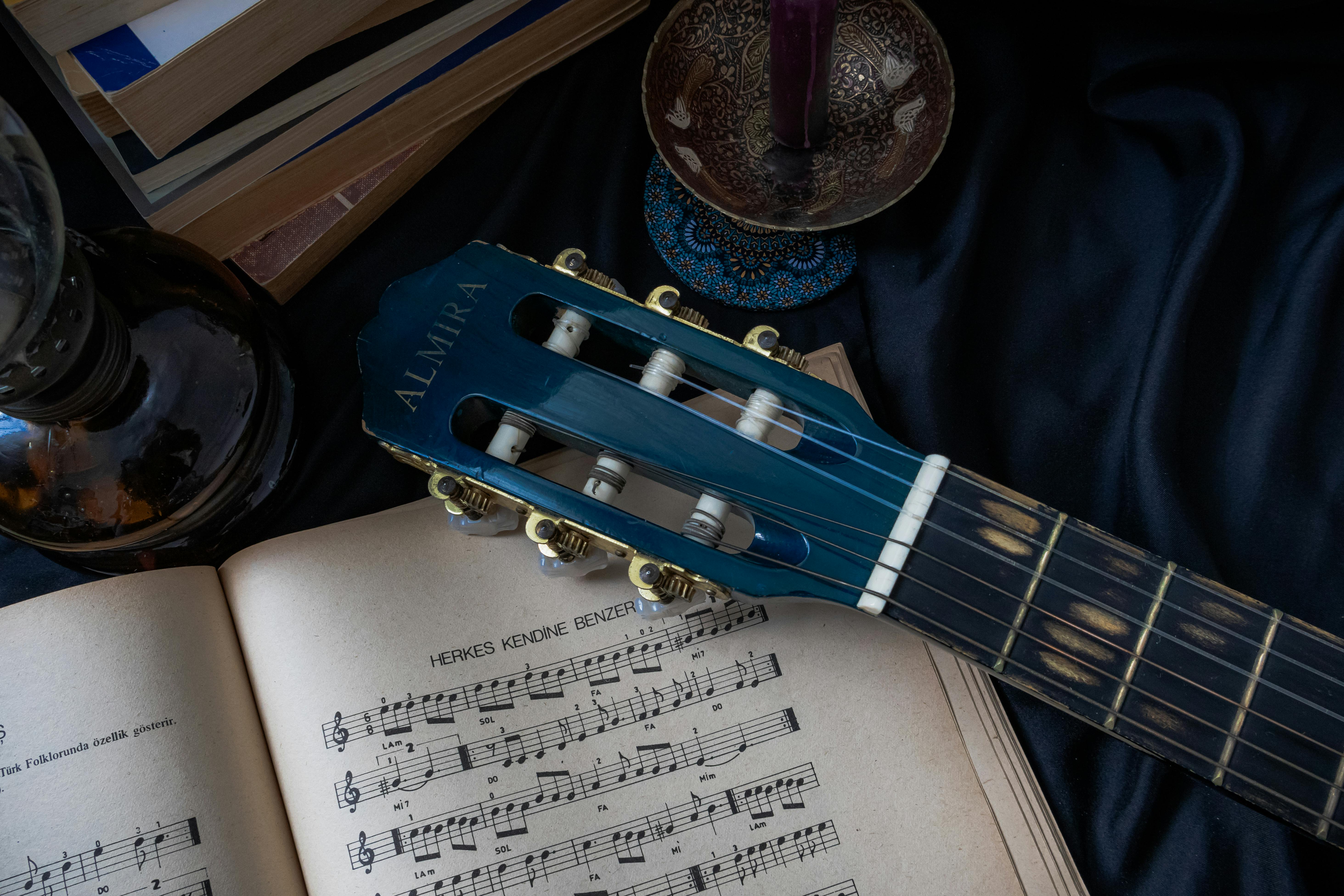 Vintage Guitar and Sheet Music Still Life Scene · Free Stock Photo