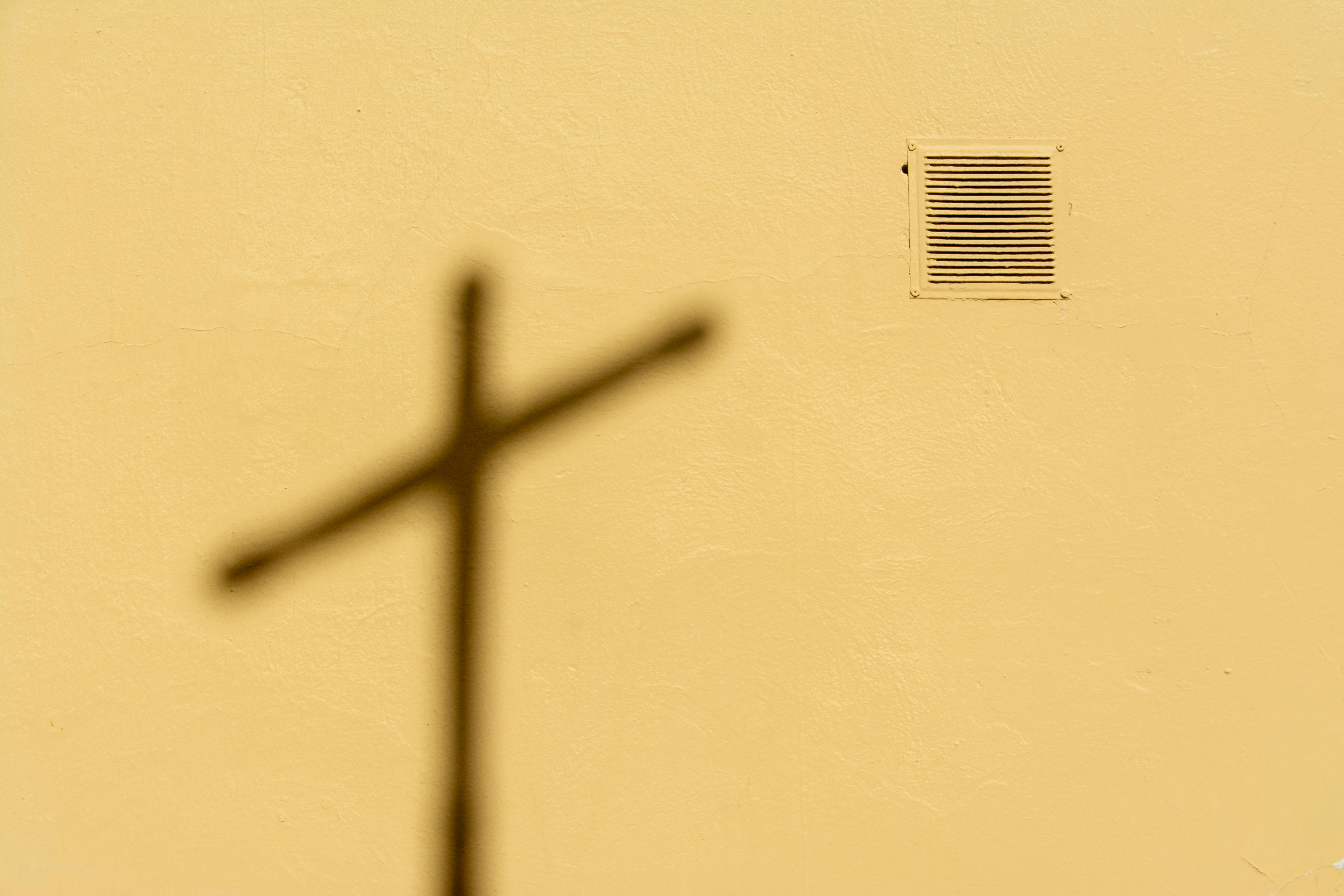 Shadow of Cross on Minimalist Yellow Wall · Free Stock Photo