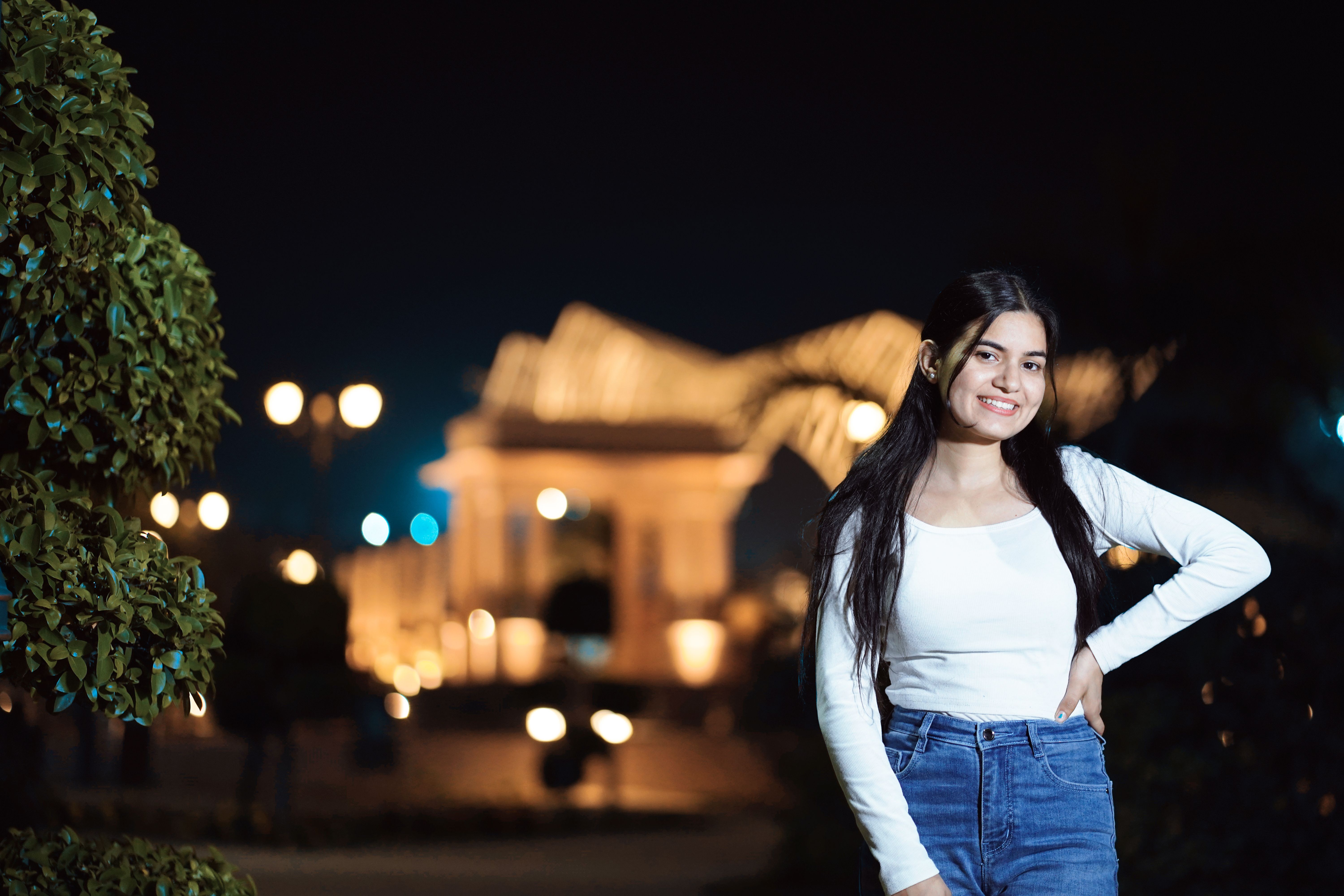 Confident Young Woman Posing Outdoors at Night · Free Stock Photo