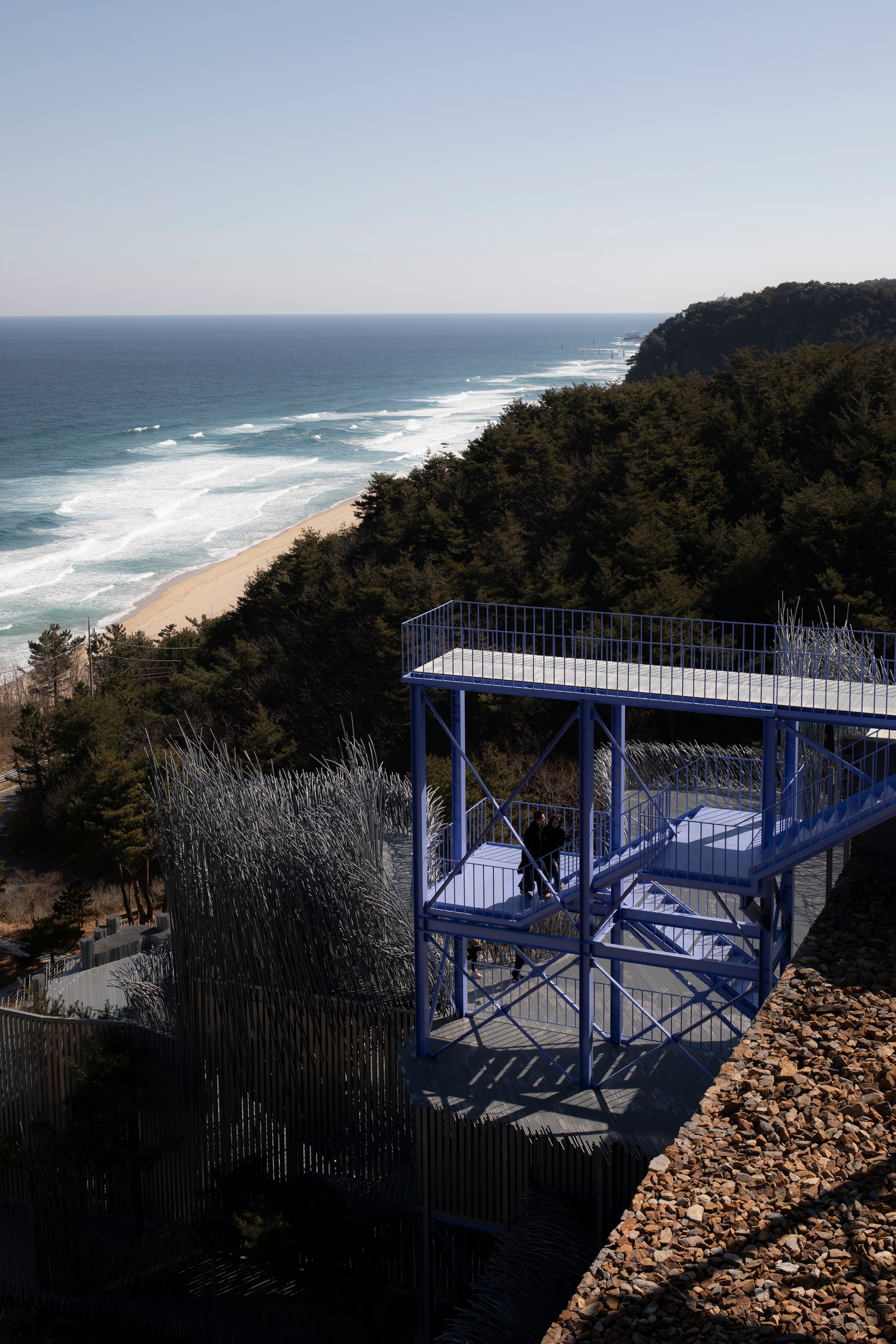 Scenic coastal view with unique blue structure · Free Stock Photo