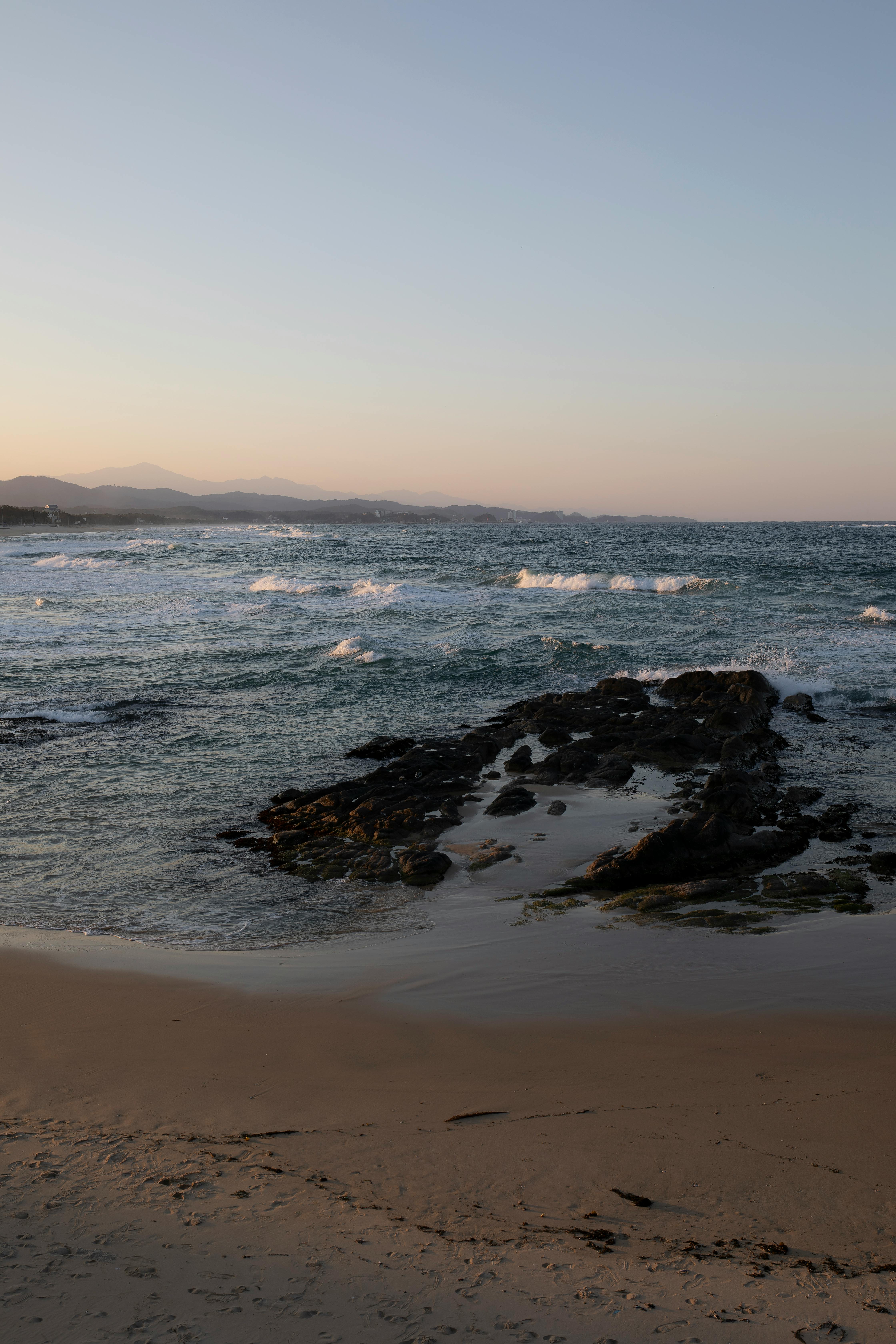 Scenic Ocean View at Sunset with Rocky Shore · Free Stock Photo