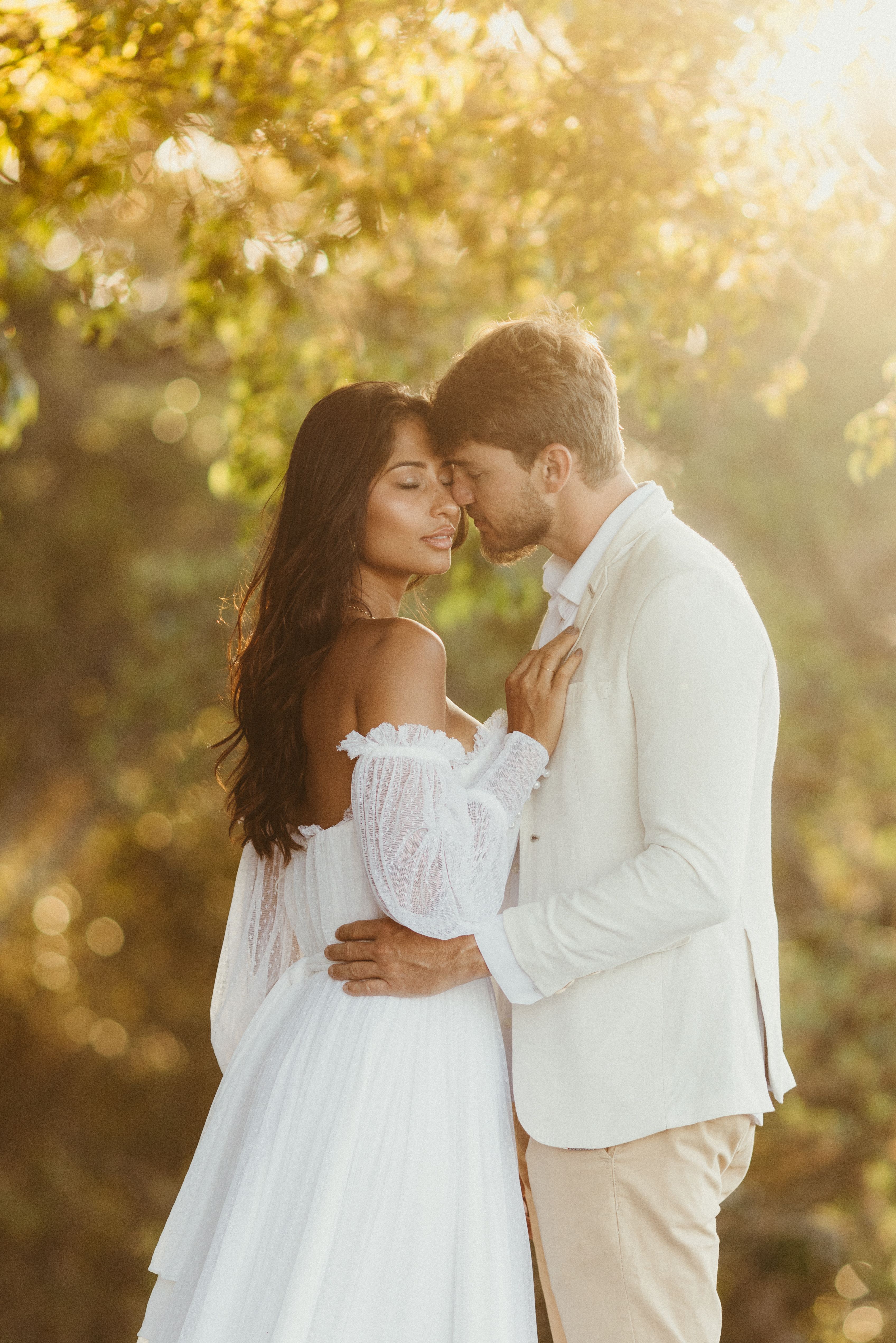 Romantic Outdoor Couple Embracing in Sunlit Setting · Free Stock Photo