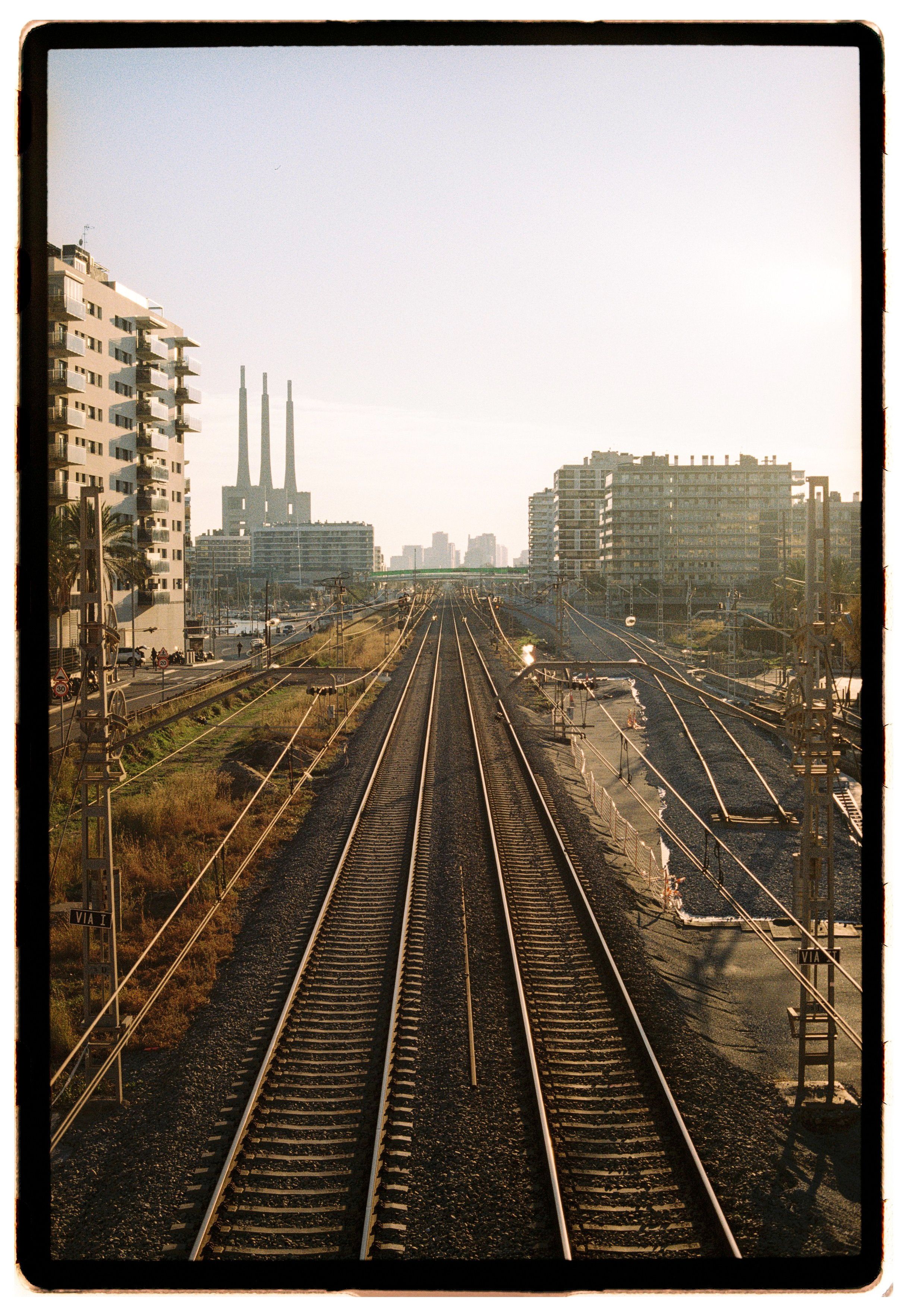 Urban Railway Tracks at Sunset with Cityscape · Free Stock Photo
