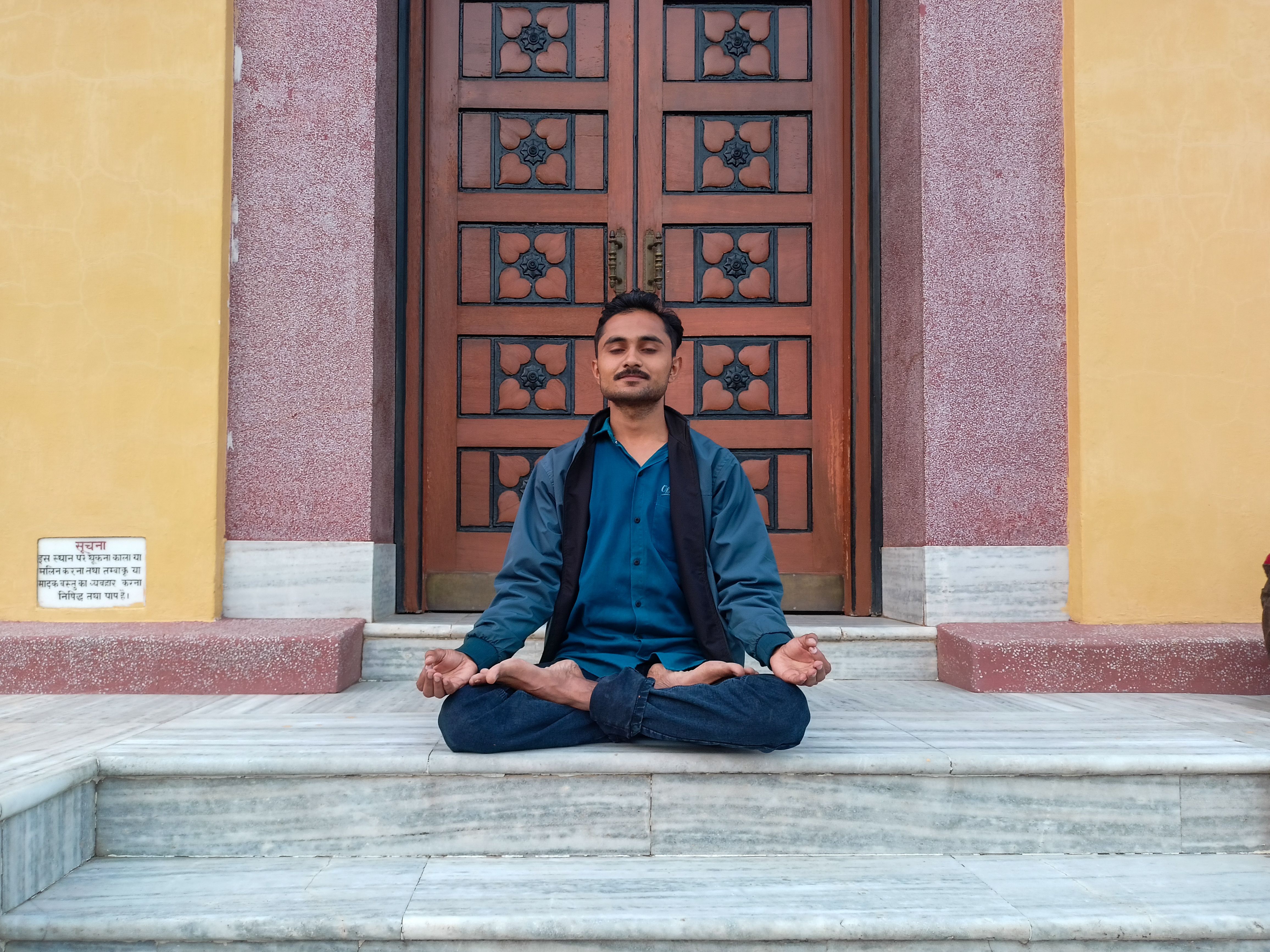 Man Meditating at Monastery Entrance · Free Stock Photo