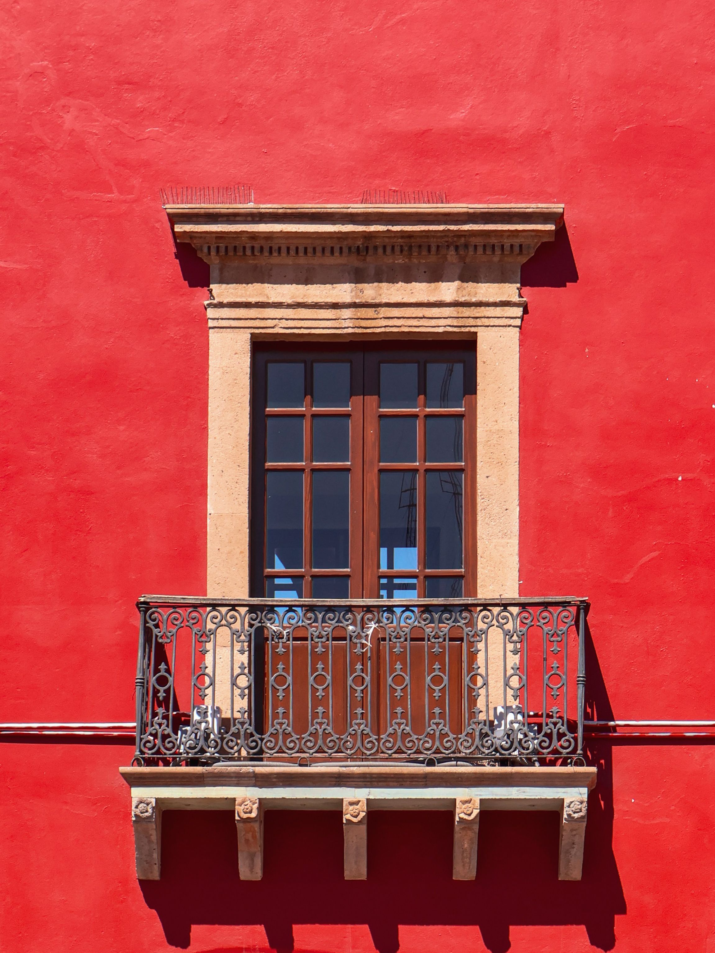 Vibrant Red Wall with Elegant Window and Balcony · Free Stock Photo