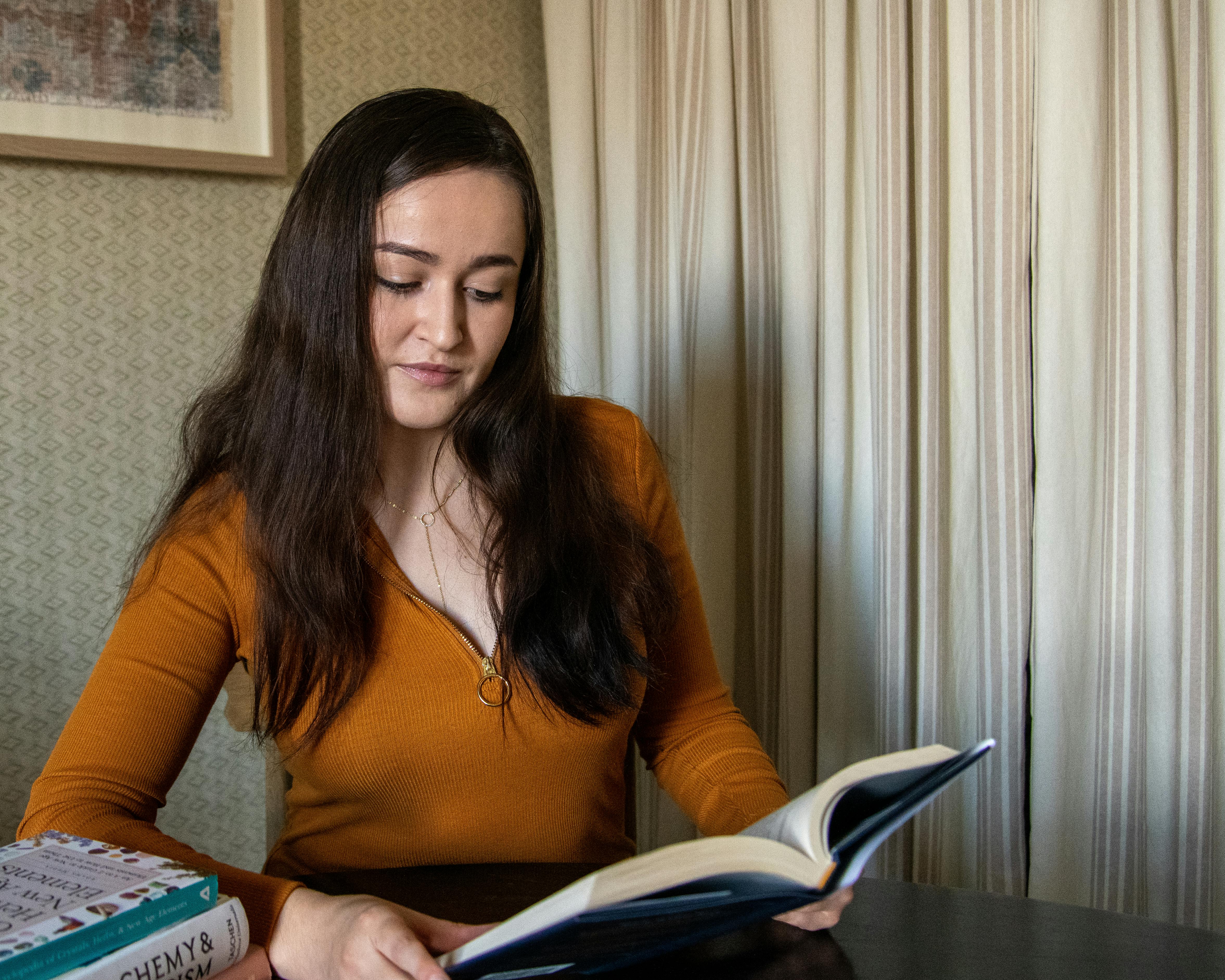 Young woman immersed in reading a book indoors · Free Stock Photo